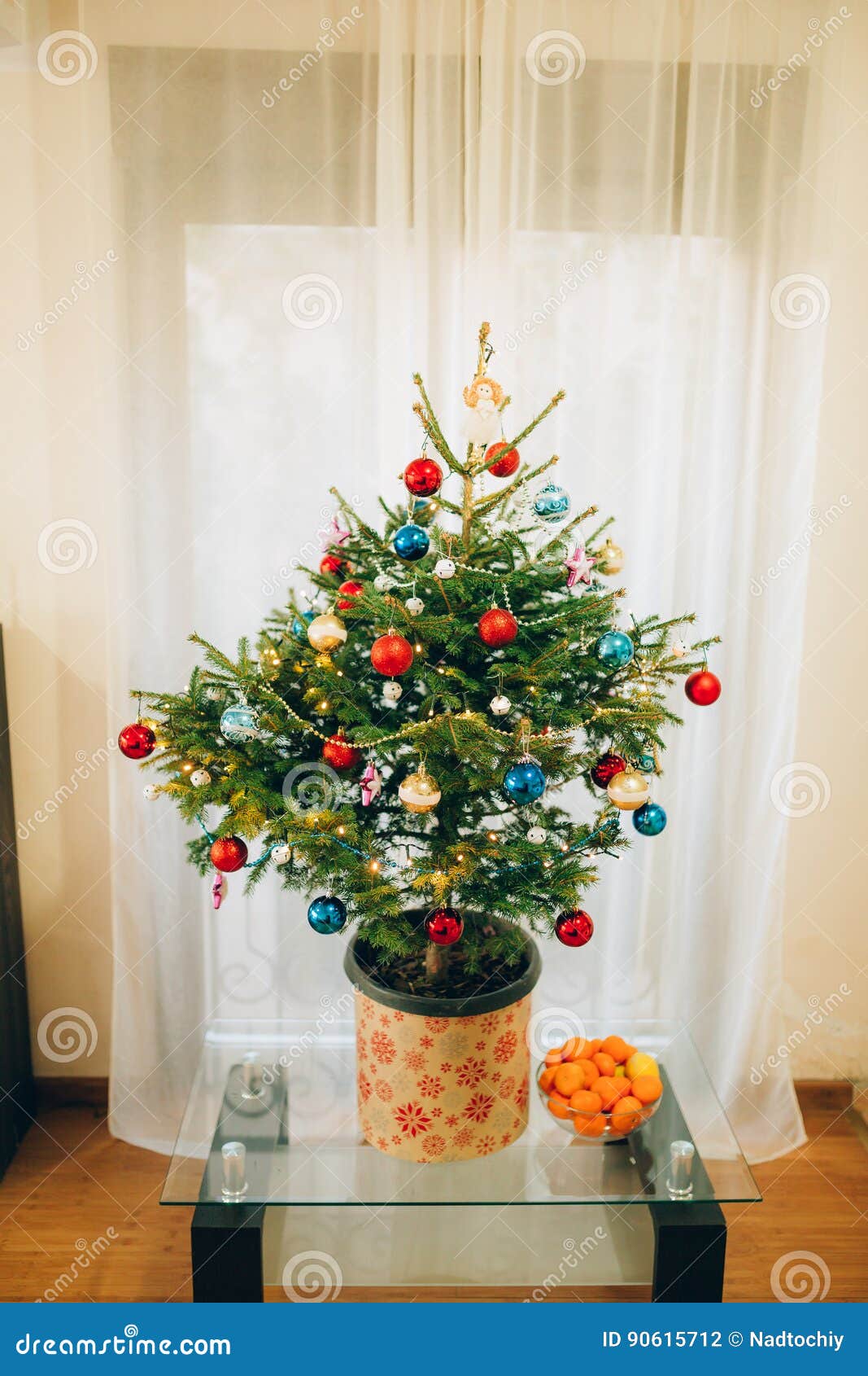 A Small Christmas Tree in a Pot, Decorated with Balls, Garlands Stock ...