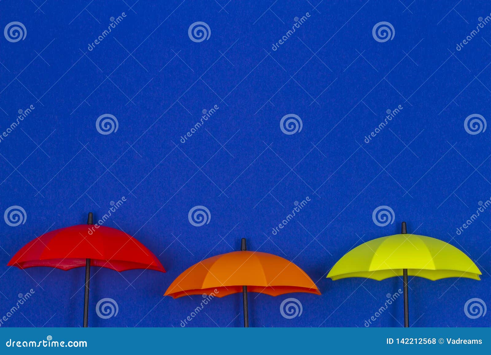 Small Colorful Umbrellas on Blue Color Background Stock Photo - Image ...