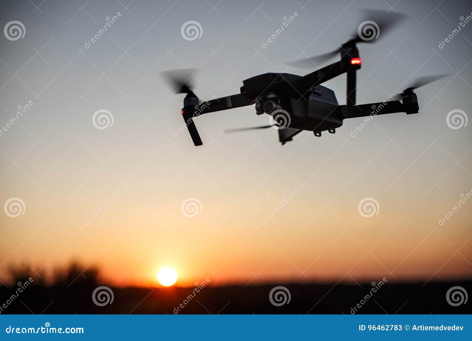 Small Compact Quadcopter Flies in the Air on Sunset. Drone Hovers and ...