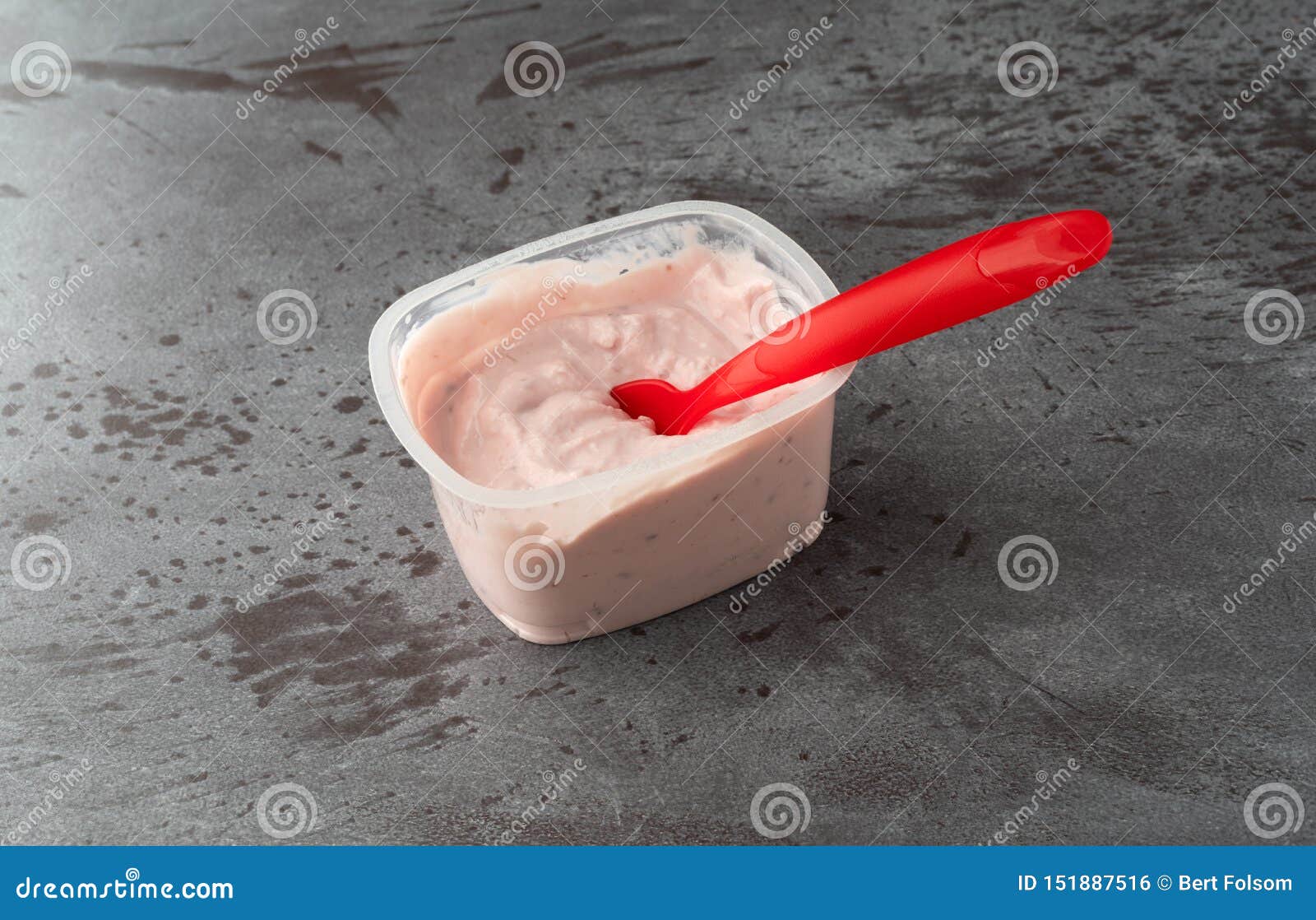 Small Container of Red Raspberry Yogurt with a Spoon in the Food on a ...