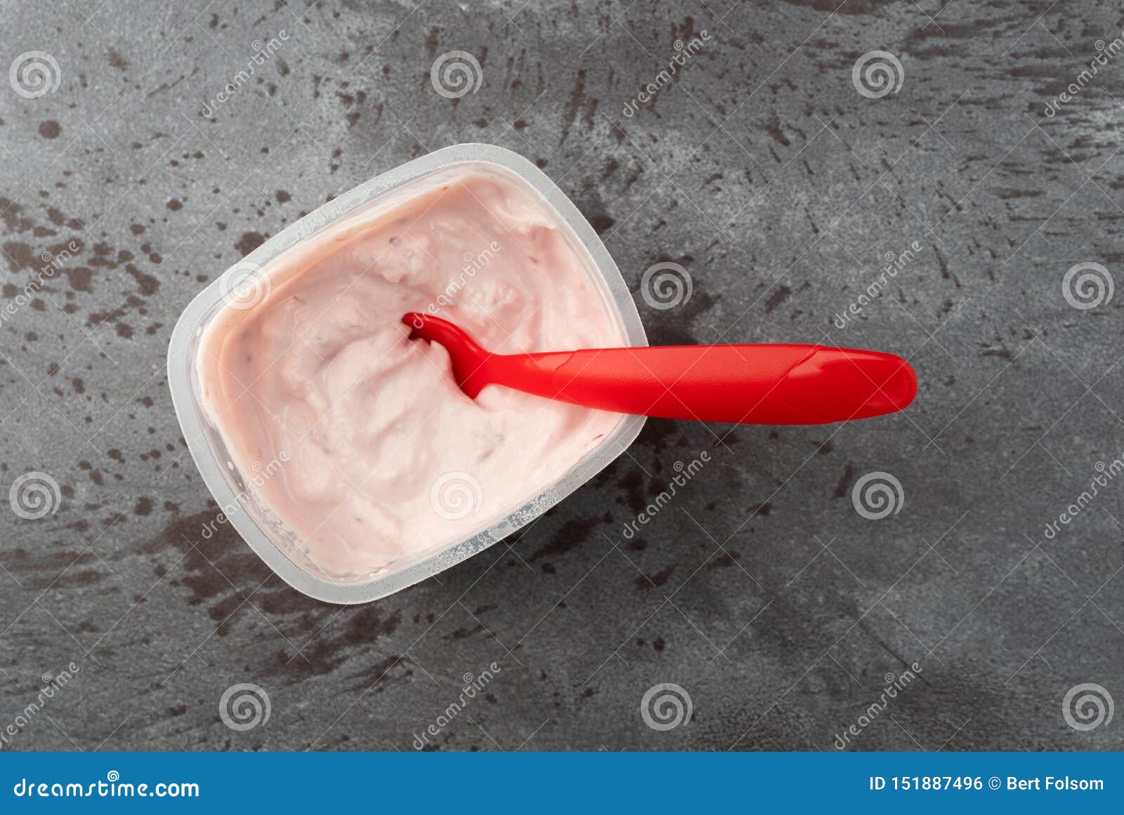 Small Container of Red Raspberry Yogurt with a Spoon in the Food on a ...