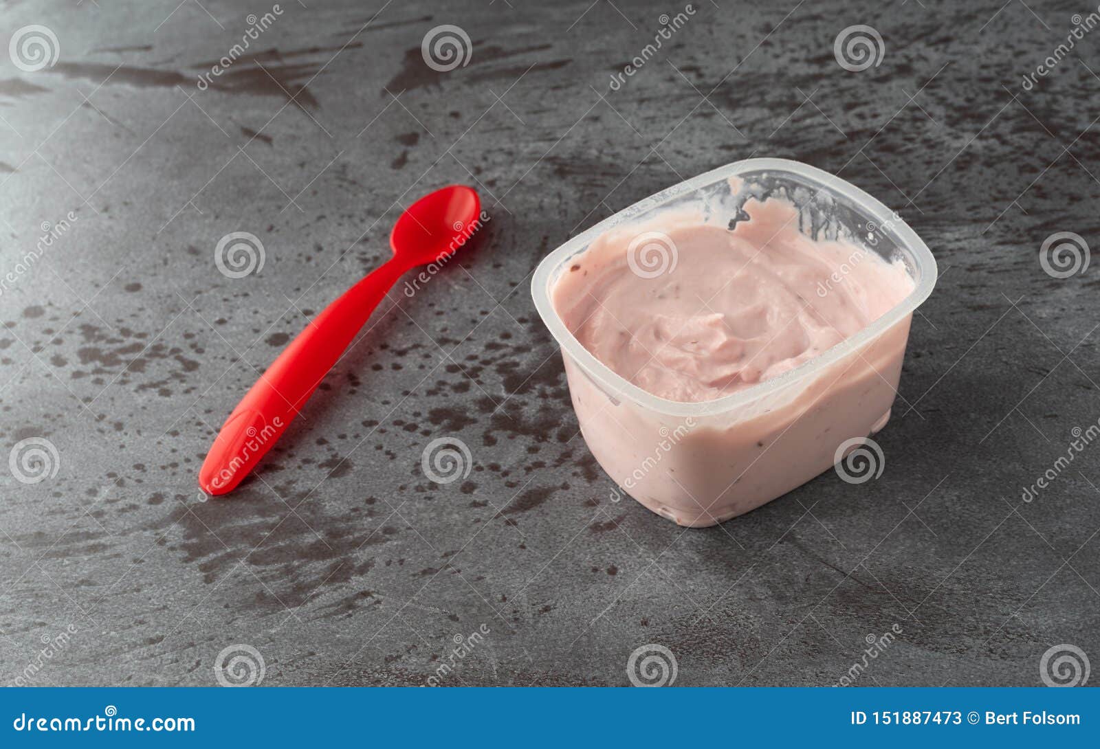 Small Container of Red Raspberry Yogurt with a Spoon To the Side on a ...