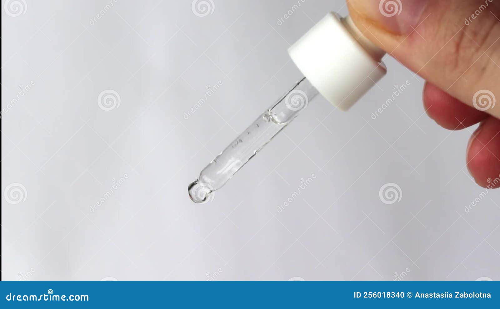 Small Cosmetic Pipette with a Transparent Serum in Hand, Dripping on ...