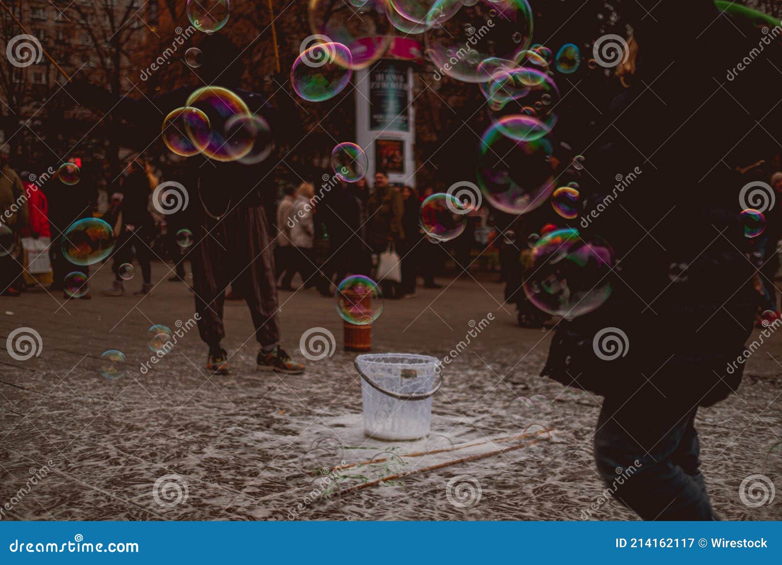 Small Crowd Gathered Around a Bucket with Soap Bubbles Outdoors Stock ...