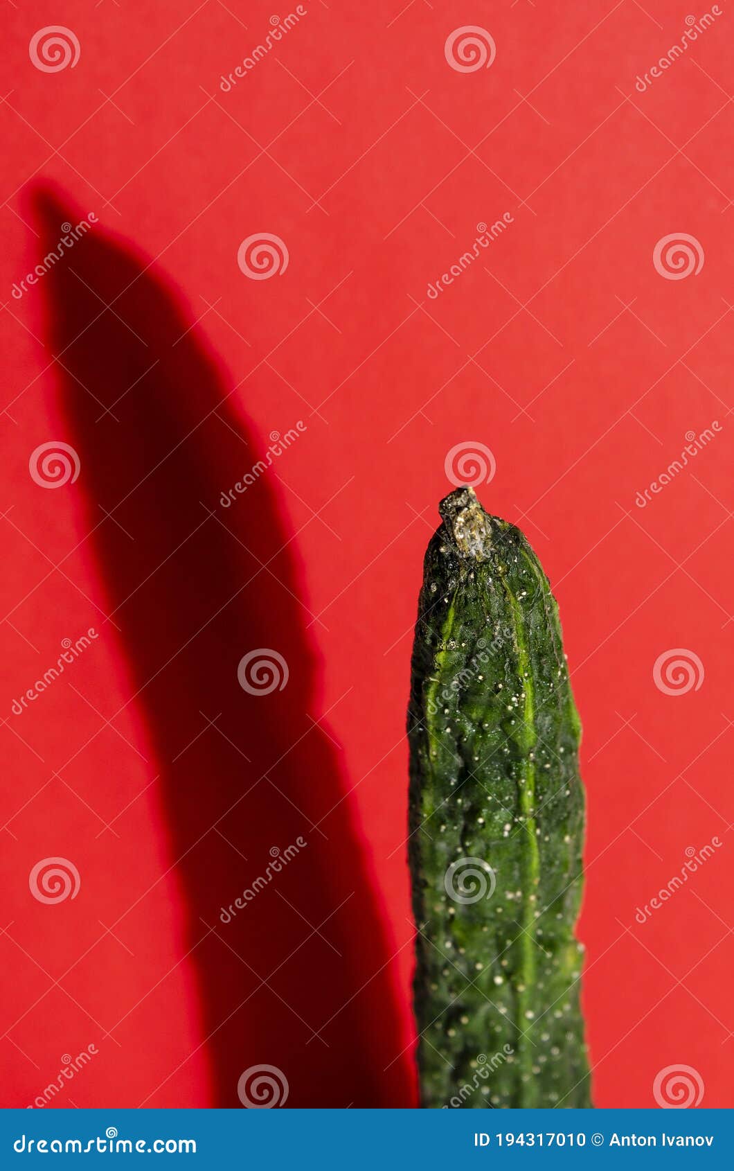 Small Cucumber And Big Shadow On A Red Background Concept Of A Small Penis Concept Of A Large