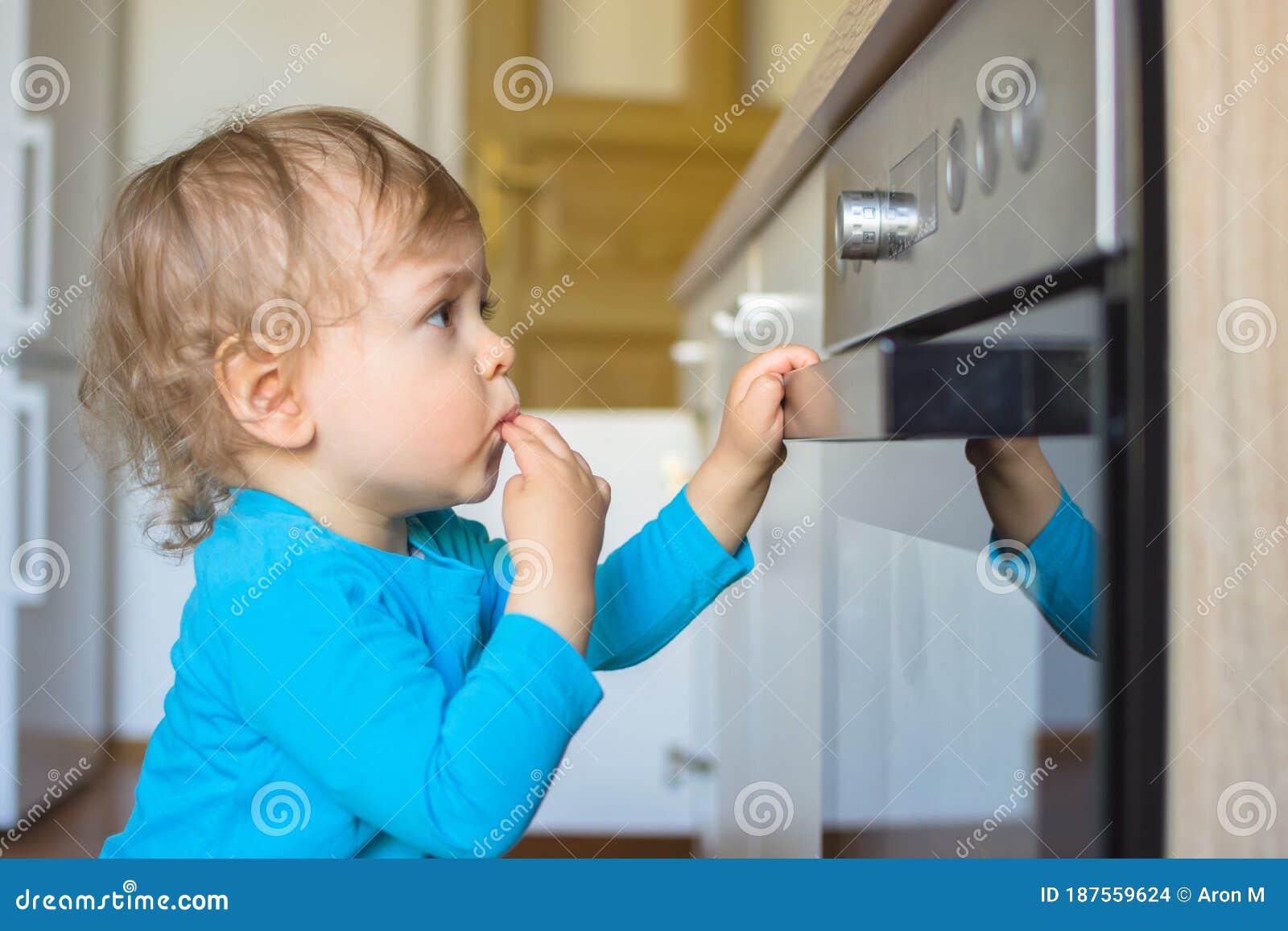 Small and Curious Child Playing with the Knobs of the Oven in the ...