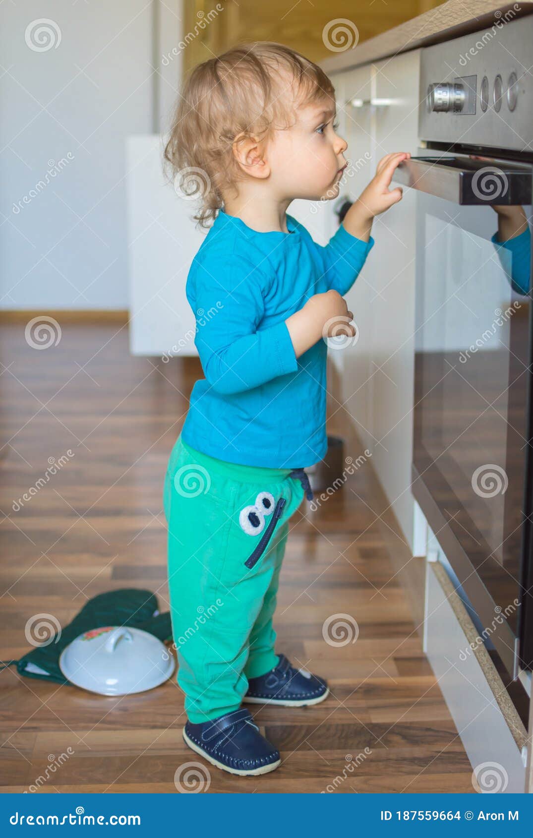 Small and Curious Child Playing with the Knobs of the Oven in the ...
