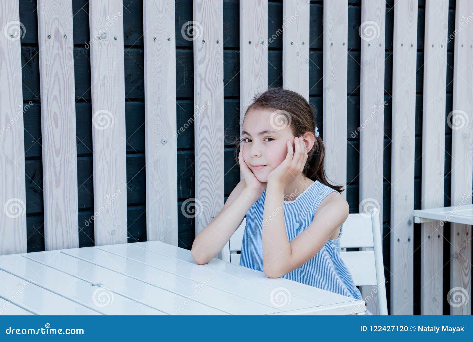 Small Cute Girl Sits at the Empty Table of a Street Cafe Stock Photo ...