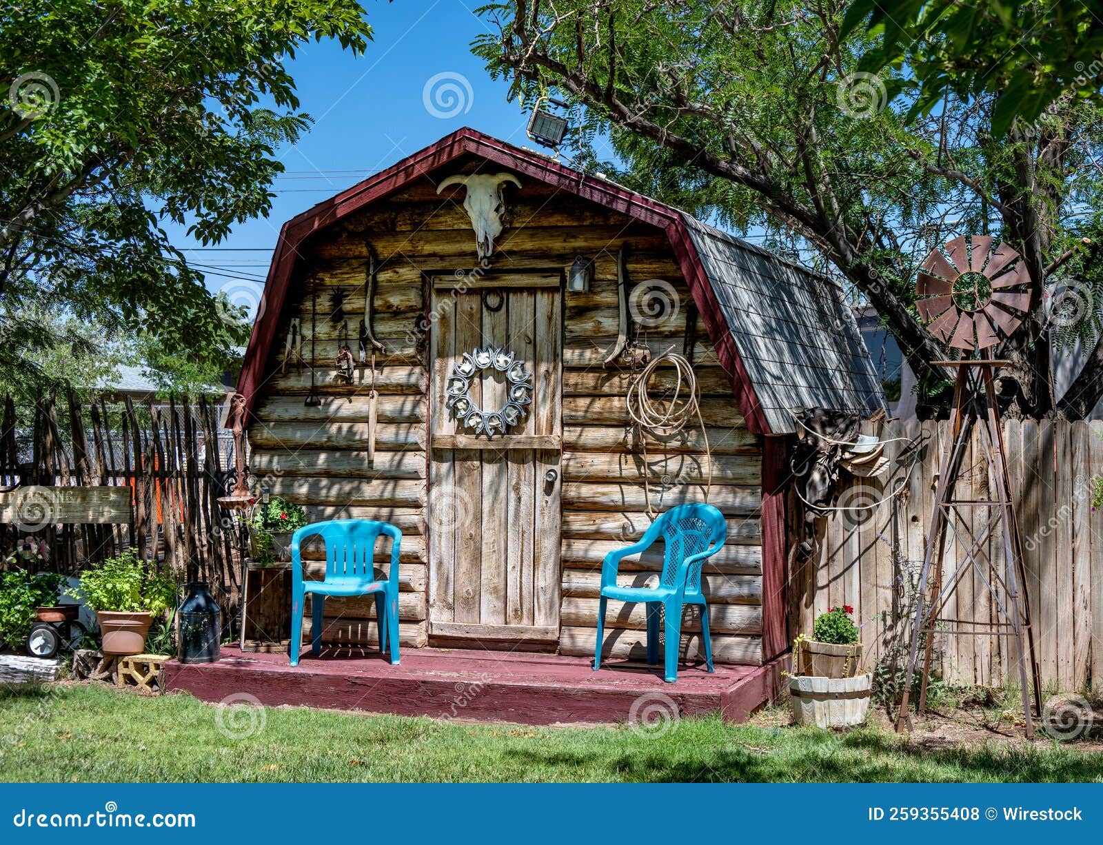 Small Cute Log Cabin with Empty Blue Plastic Chairs in the Backyard ...