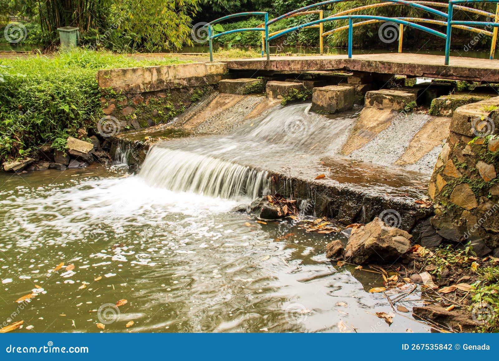 A Small Dam with a Bridge Over it with a Stream of Water Flowing Below ...