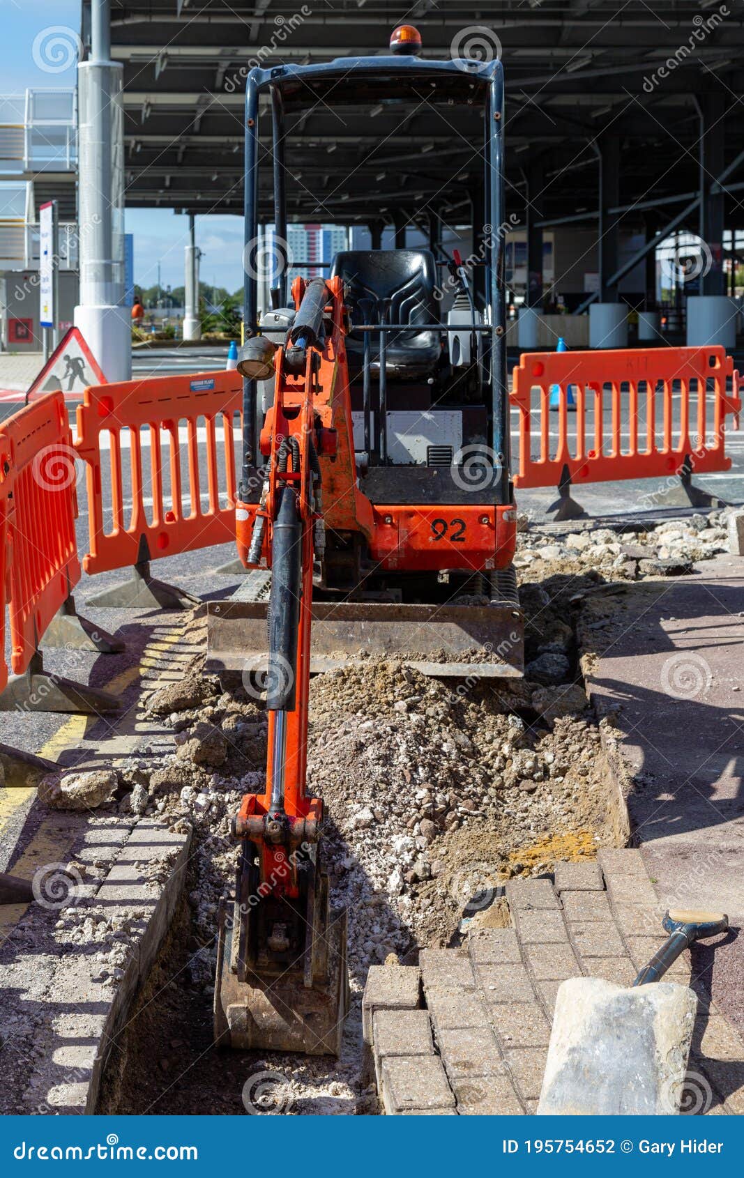 A Small Digger Digging Up the Pavement during Ground Works Editorial ...