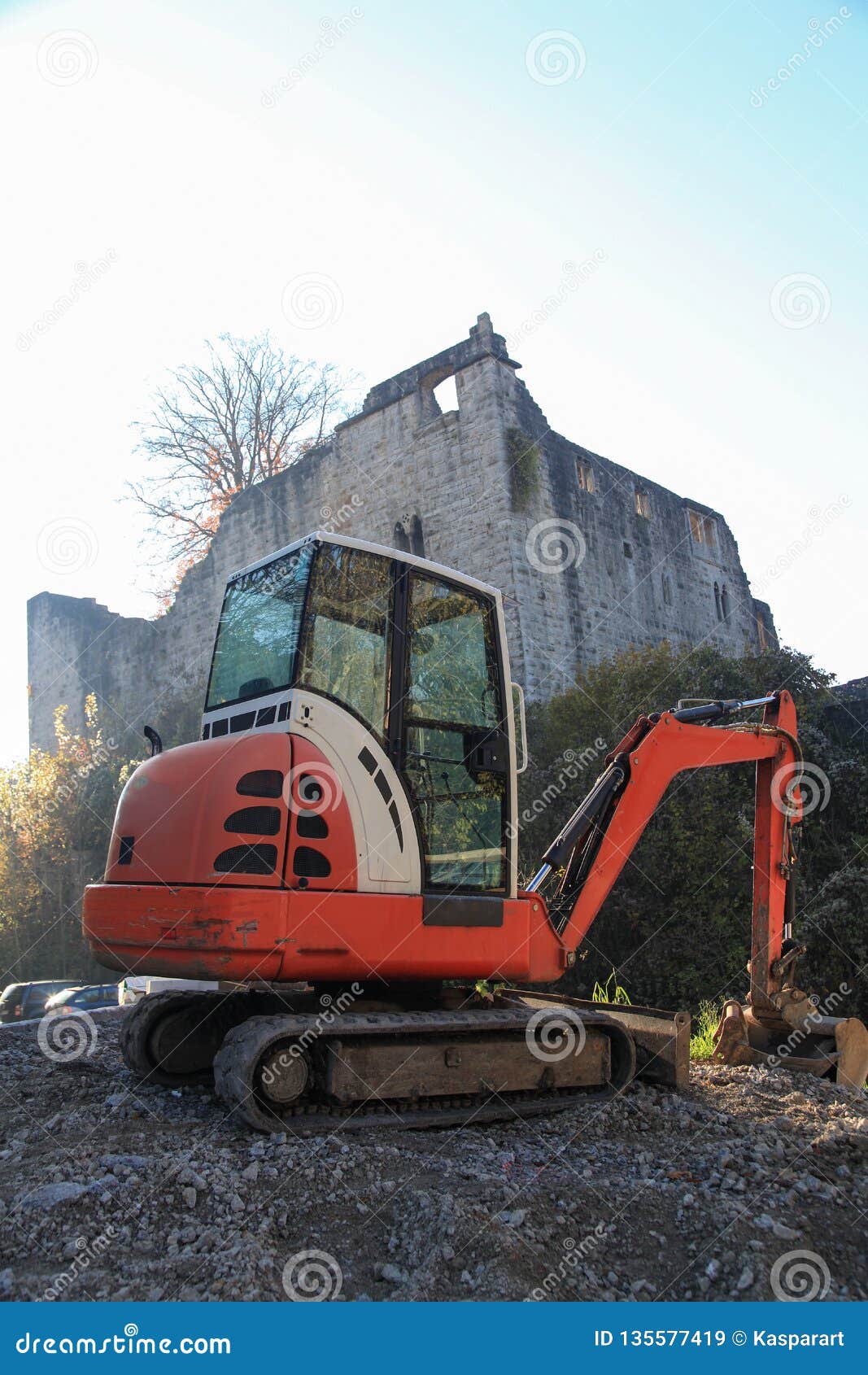 Small Excavator on a Consruction Site Hill in Front of an Ancient ...