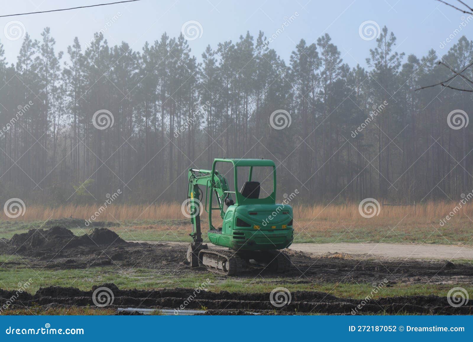 A Small Excavator Digging a Ditch on a Construction Site Stock Photo ...