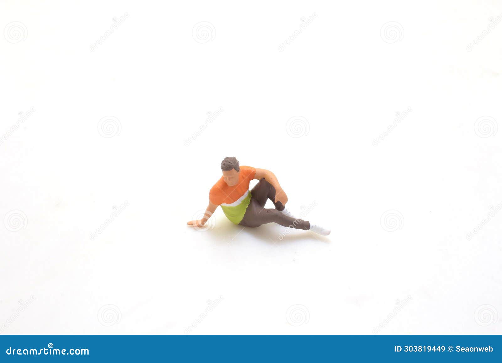 Small Figure Performing a Stretch Alone with a Plain Backdrop Stock ...