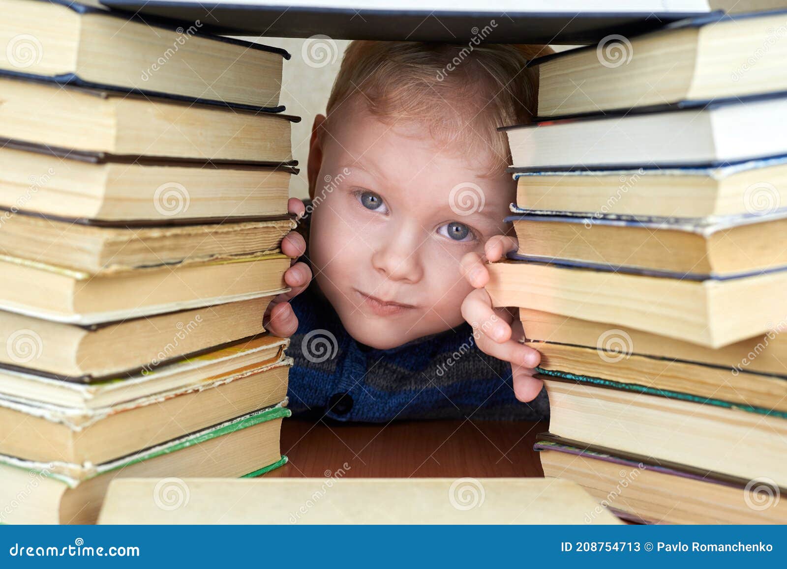 A Small Funny Boy Looks Out from a Stack of Books Stock Image - Image ...