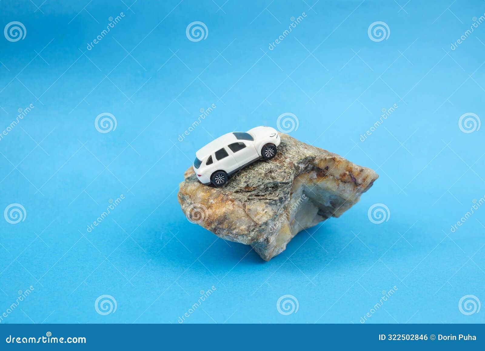 Small Generic Suv Model Car Climbing a Rock in Balance on Blue ...
