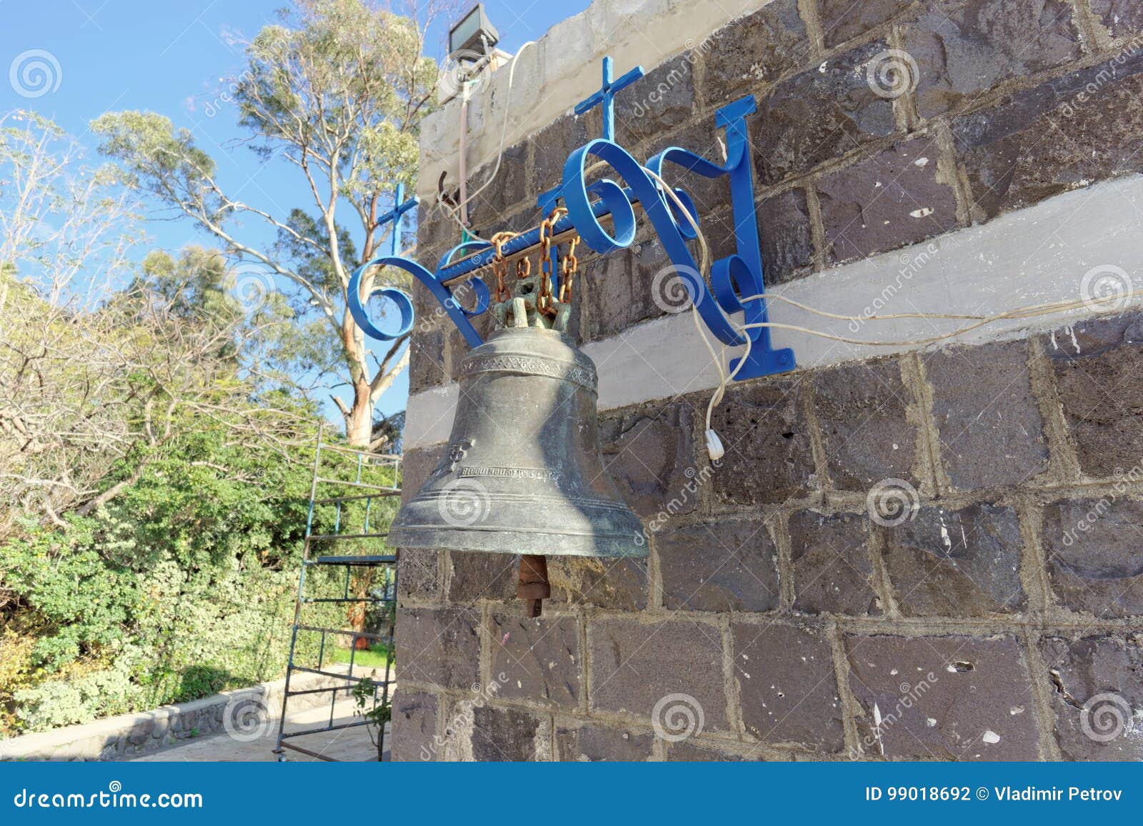 A Small Gray Stone House with a Bronze Bell Hanging on the Wall ...