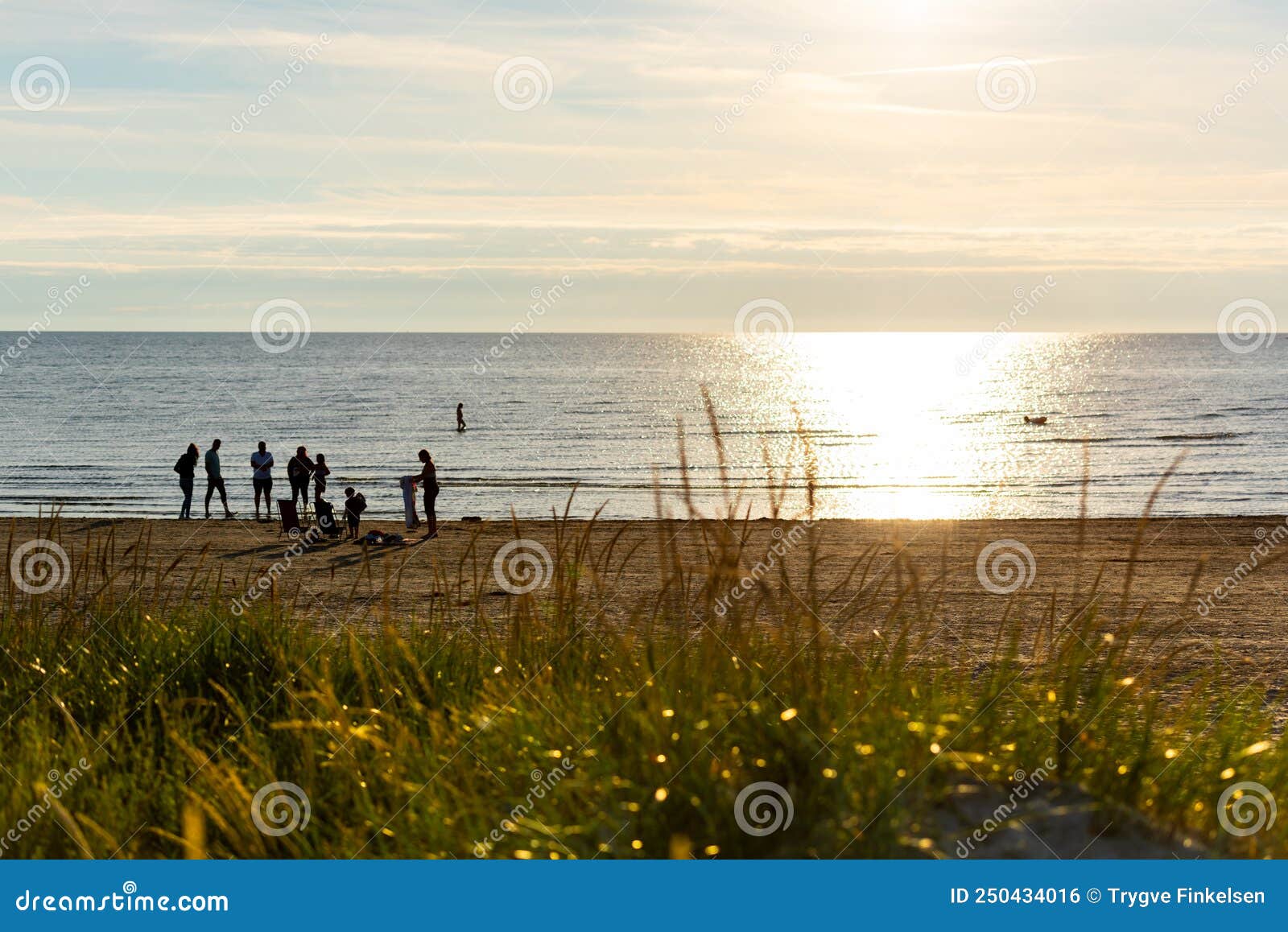 Small Group of People on a Beach at Sunset.. Stock Photo - Image of ...