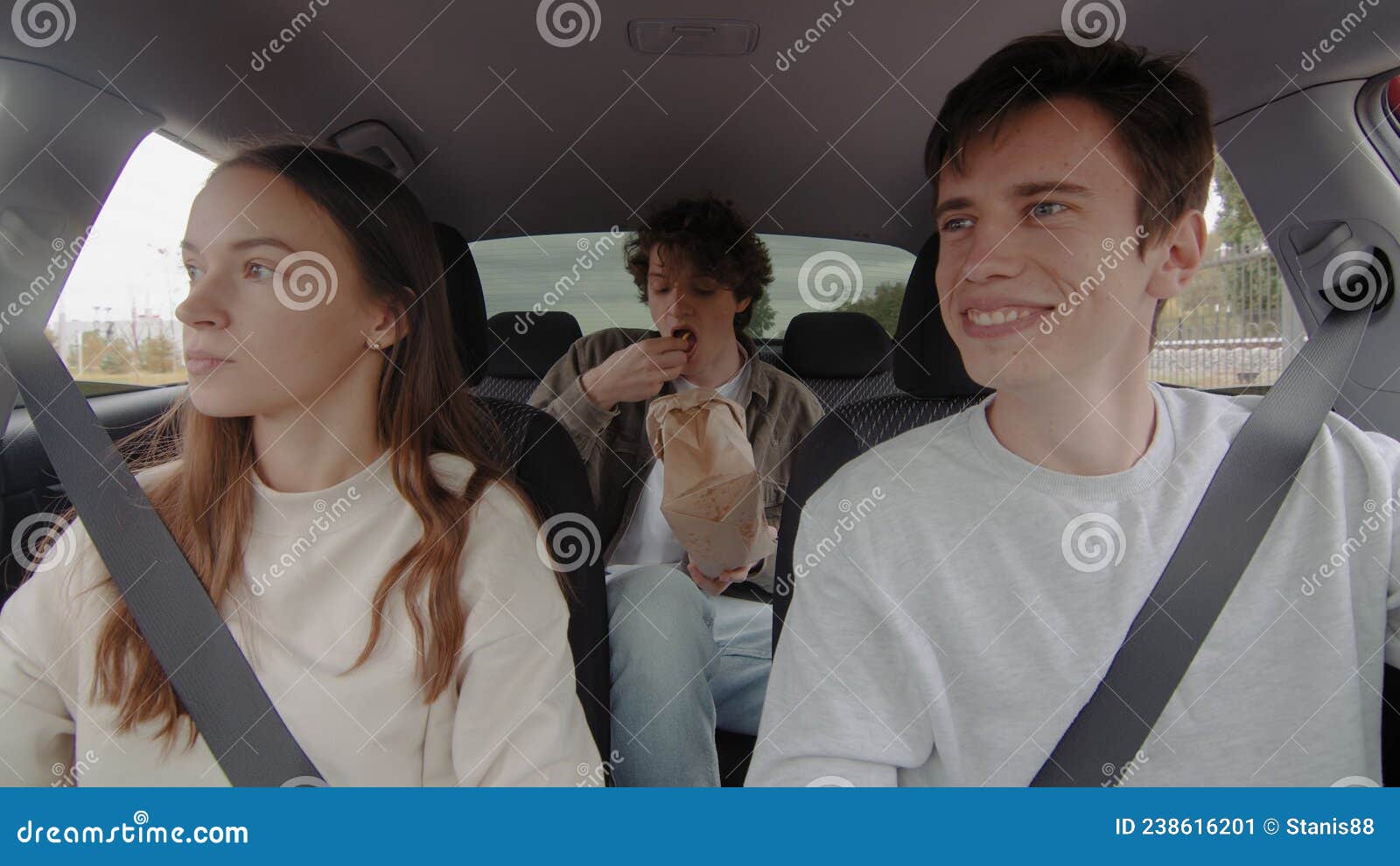 A Small Group of People are Driving in a Car and Eating Potato Chips ...