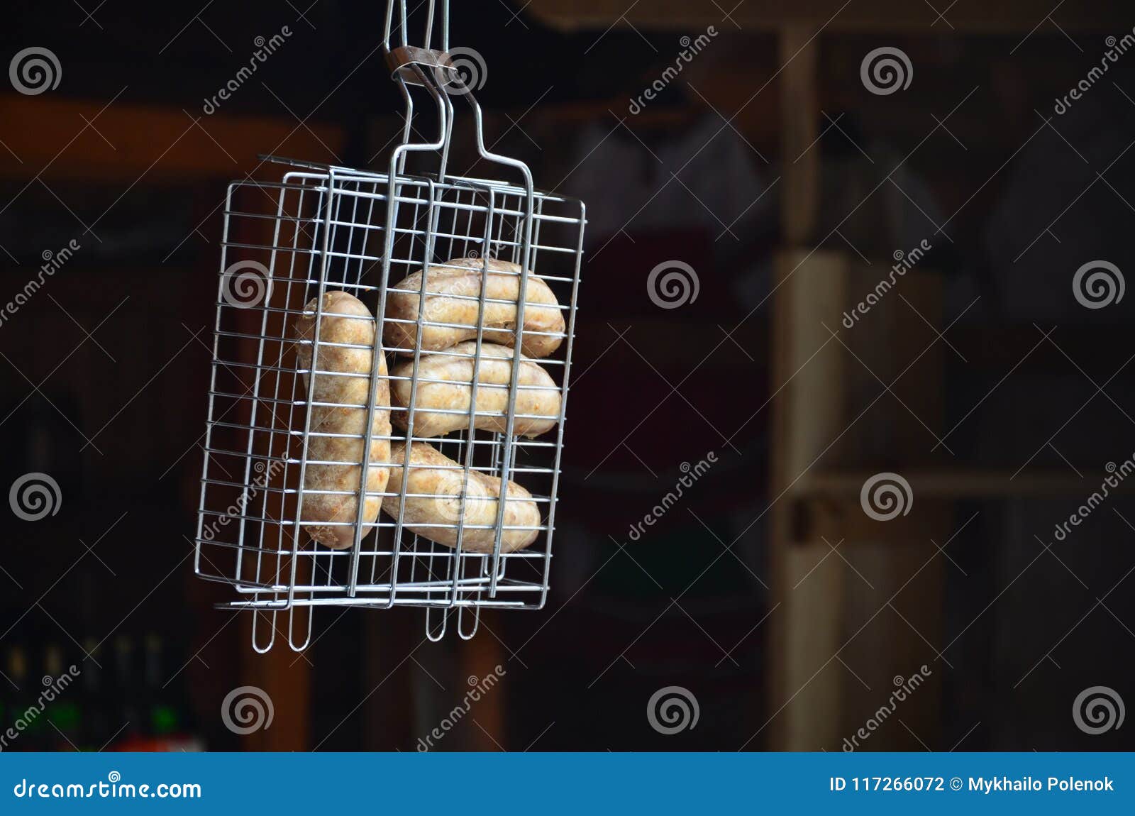 A Small Hand Grill is Filled with Fried Thick Sausages on a Dark ...