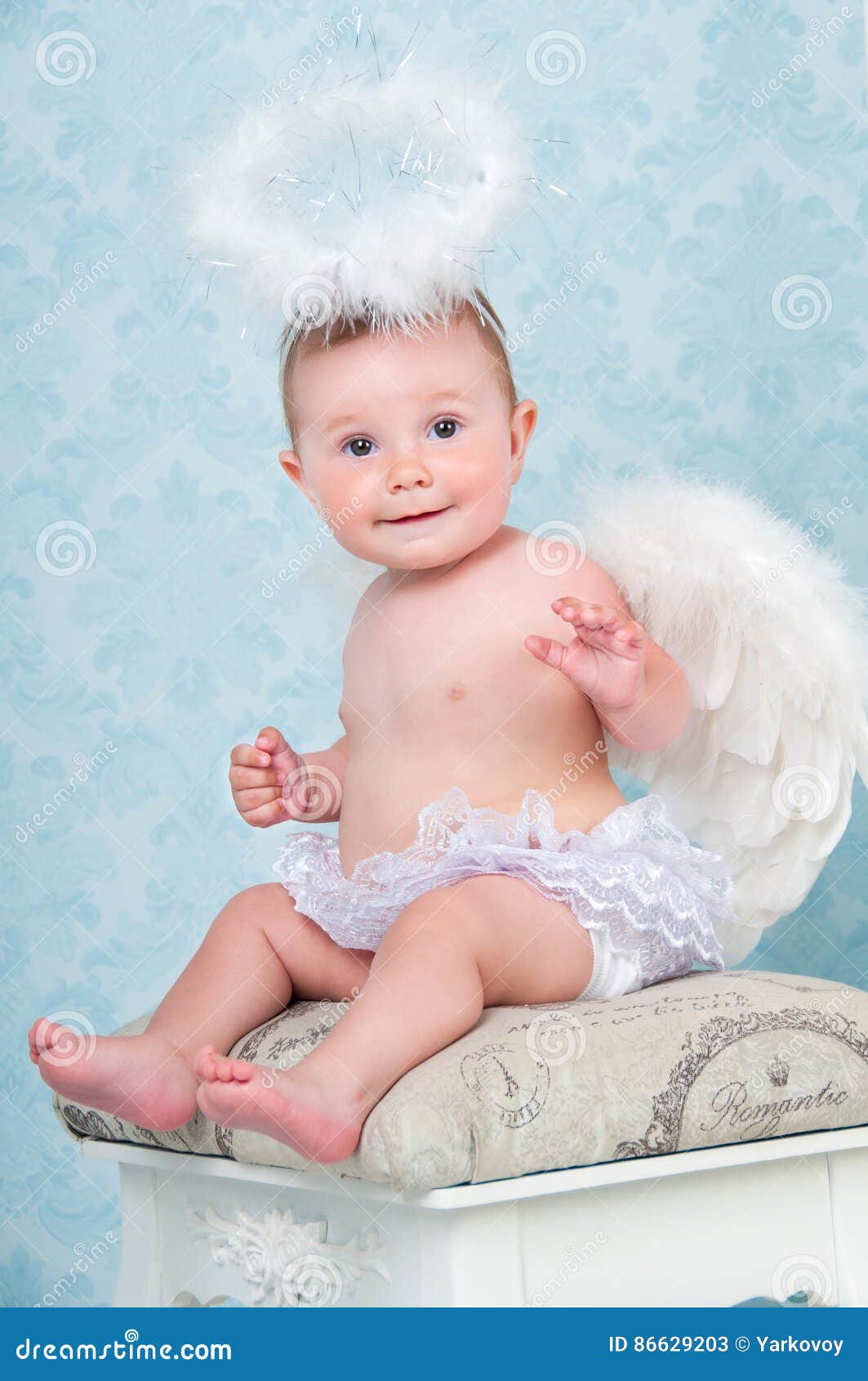 Small and Happy Angel Smiling and Sitting on a Chair. Stock Image ...