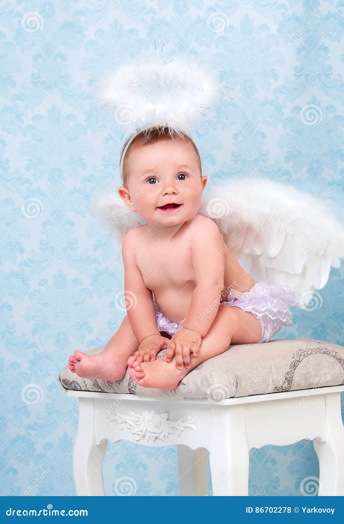 Small and Happy Angel Smiling and Sitting on a Chair. Stock Photo ...