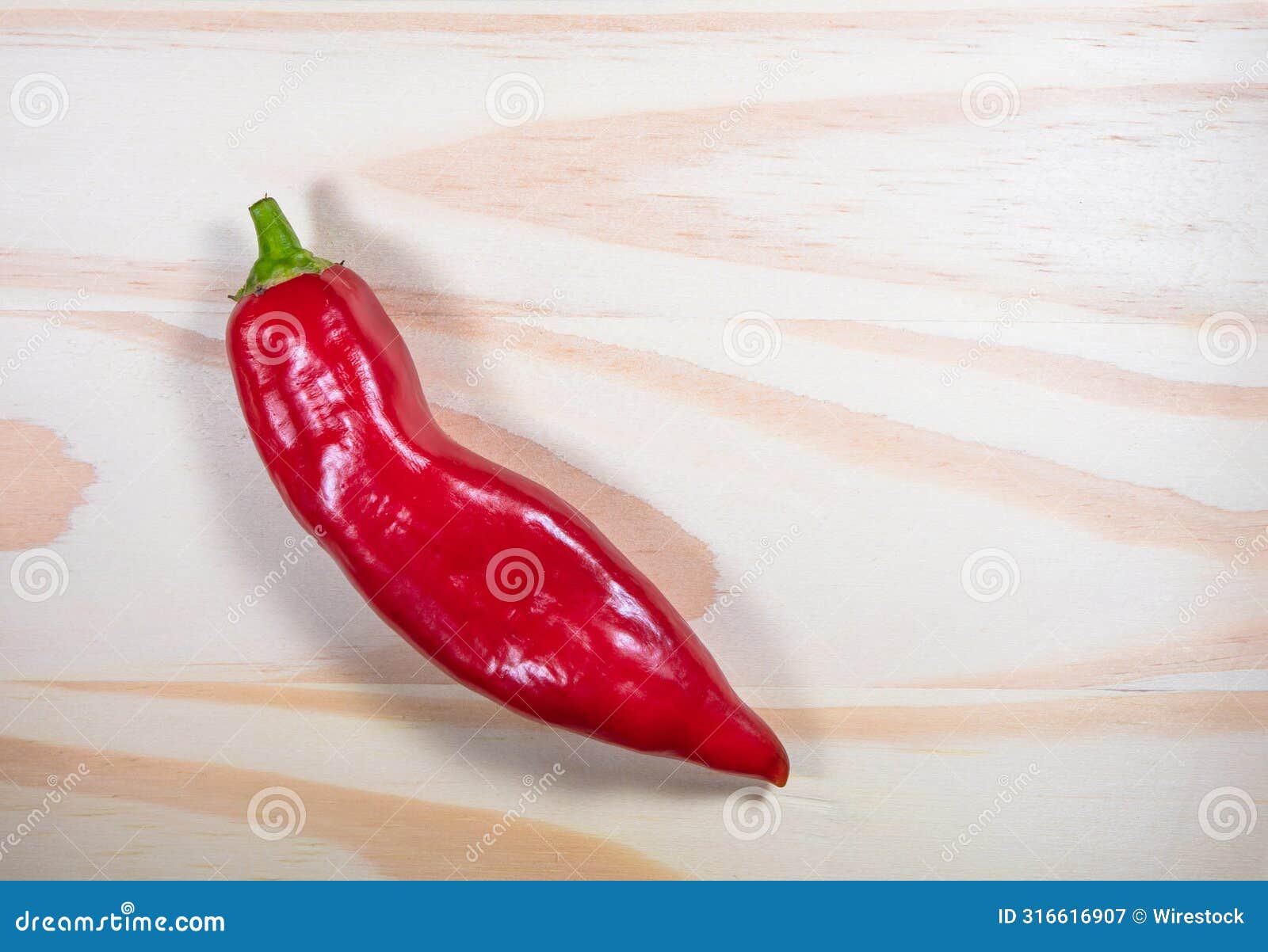 A Small Hot Pepper is on a Table, Against a White Wood Surface Stock ...