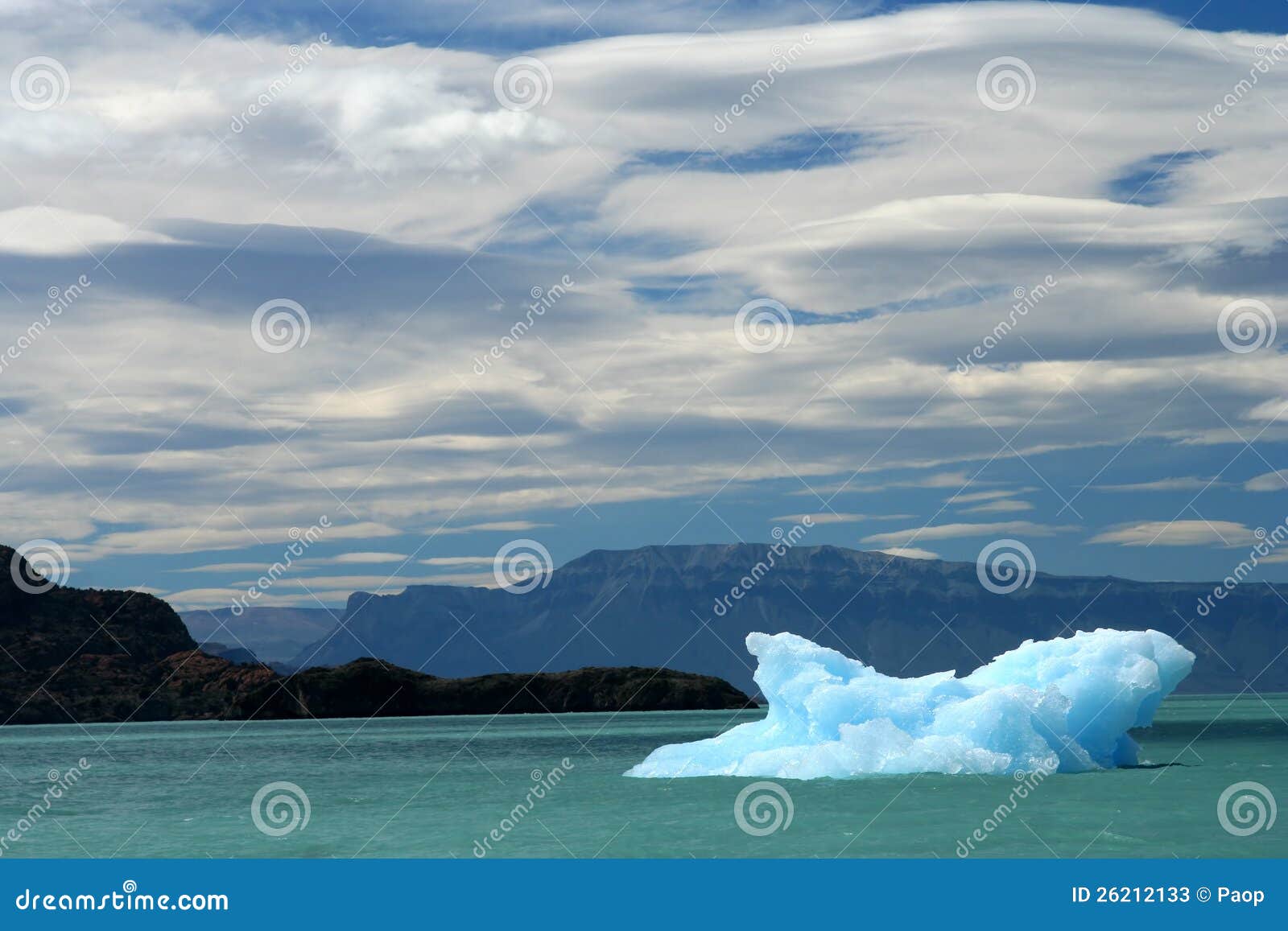 Small Iceberg In Antarctic Waters Clogged With Ice Against A Rocky ...