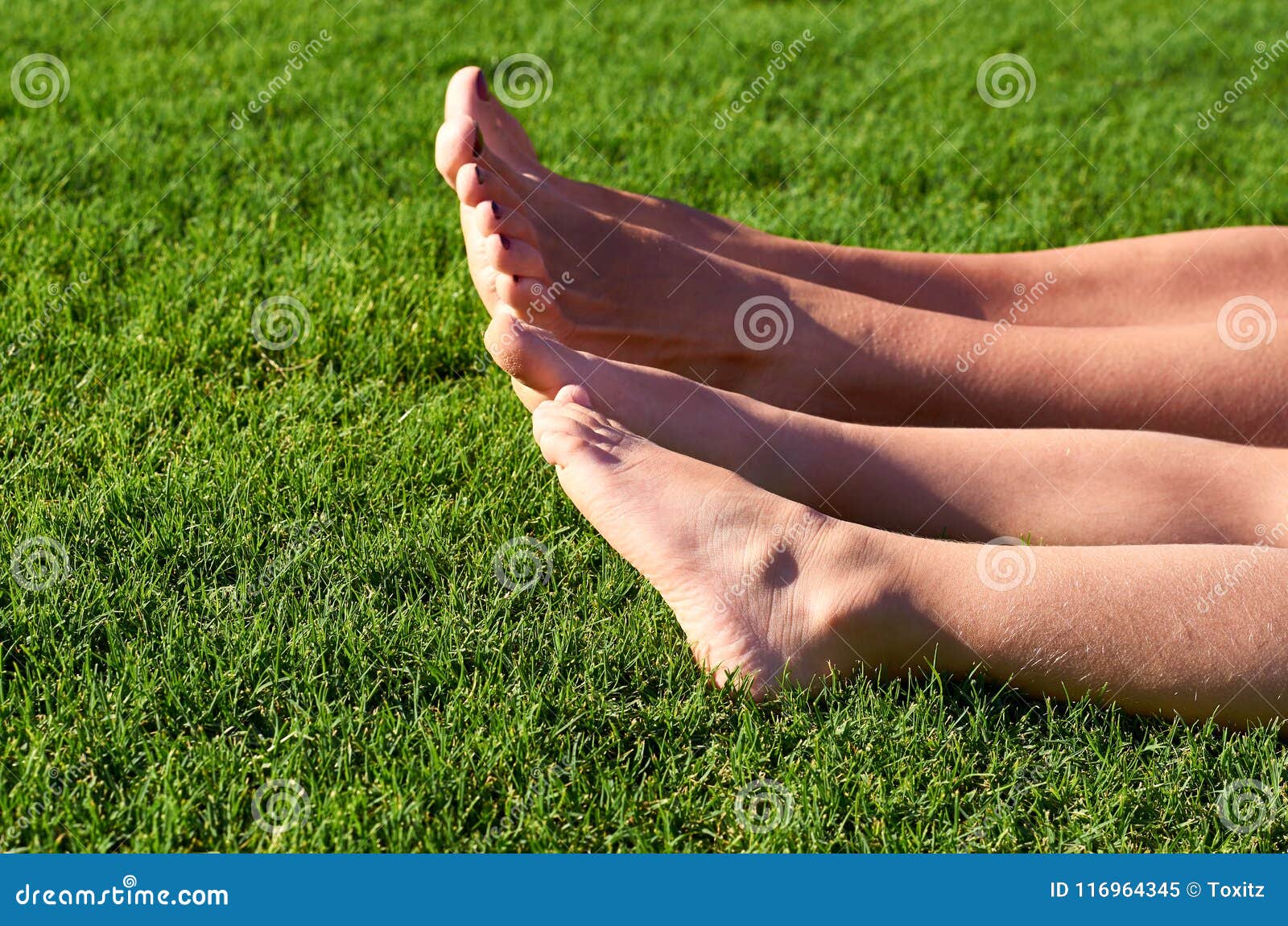 Small Kid Legs Lays on Green Grass Stock Image - Image of beautiful ...