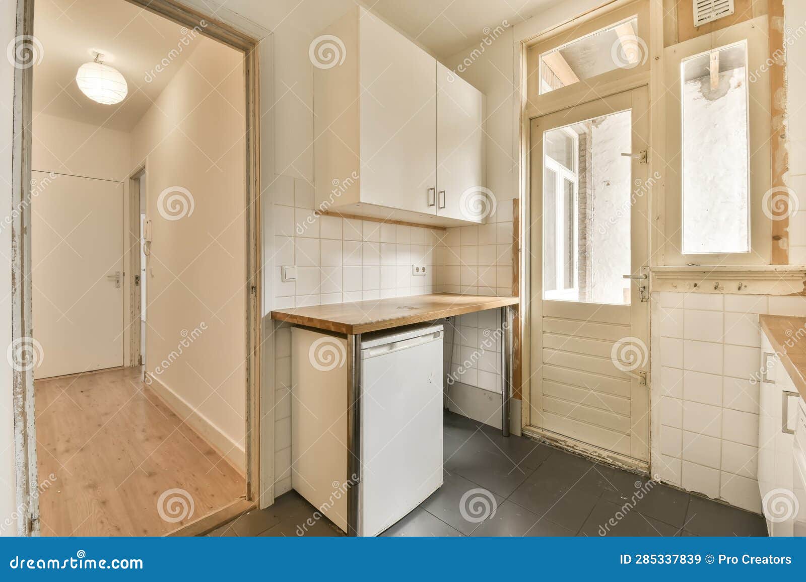 A Small Kitchen with White Cabinets and a Window Stock Image - Image of ...