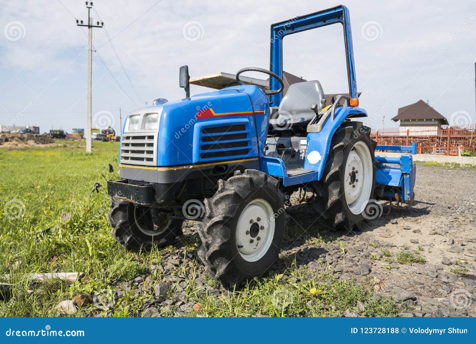 A Small Mini Blue Tractor Stands on a Farm Yard on Green Grass and ...