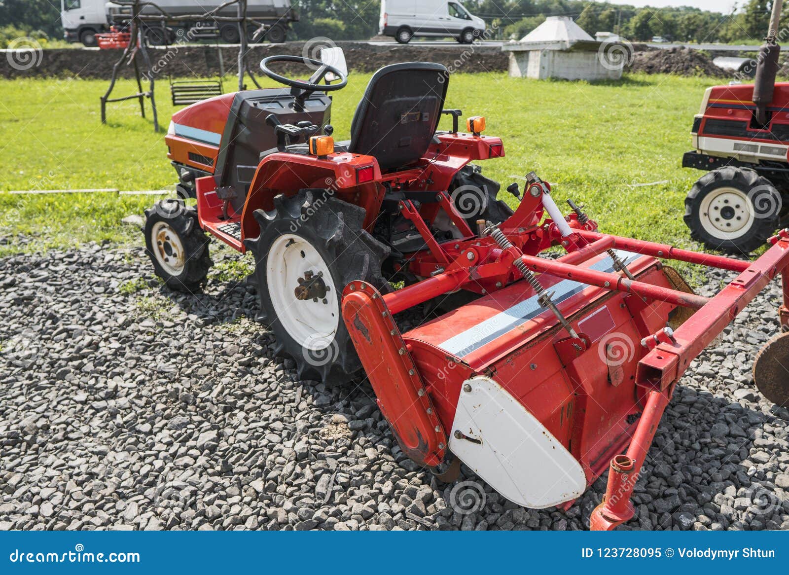 A Small Mini Red Tractor Stands on a Farm Yard on Green Grass and Waits ...