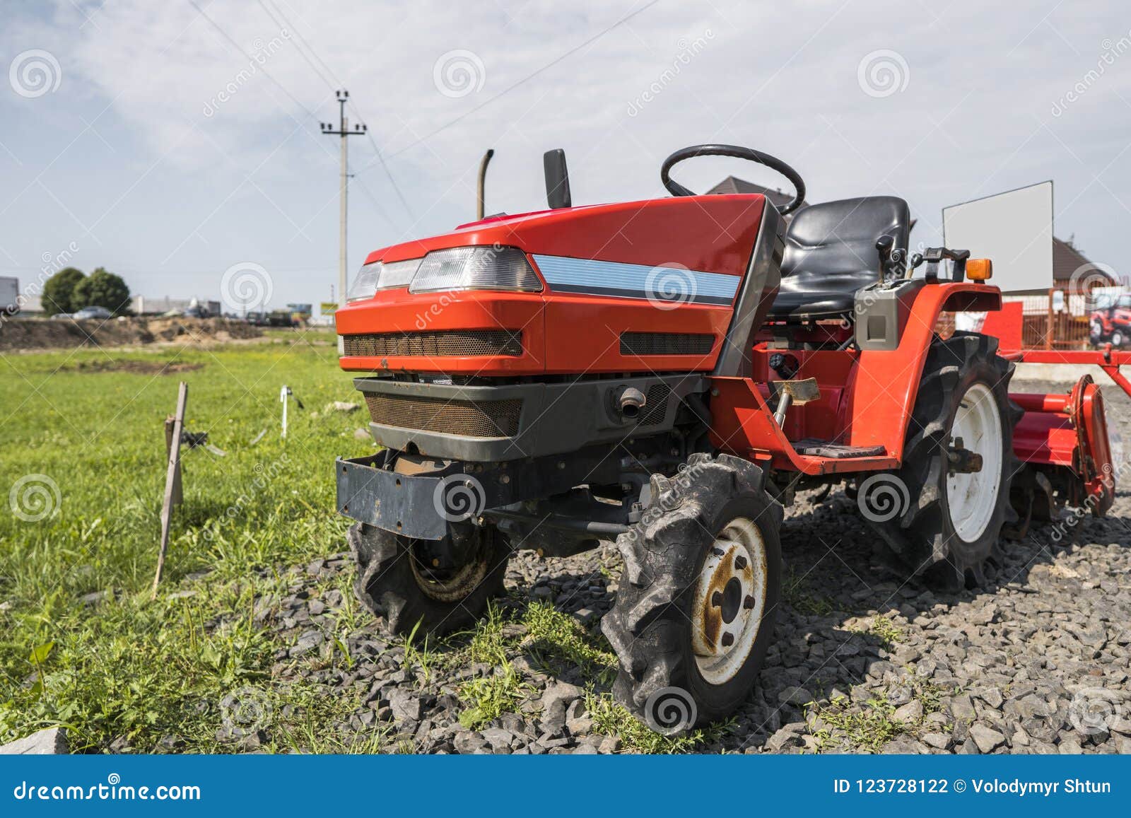 A Small Mini Red Tractor Stands on a Farm Yard on Green Grass and Waits ...