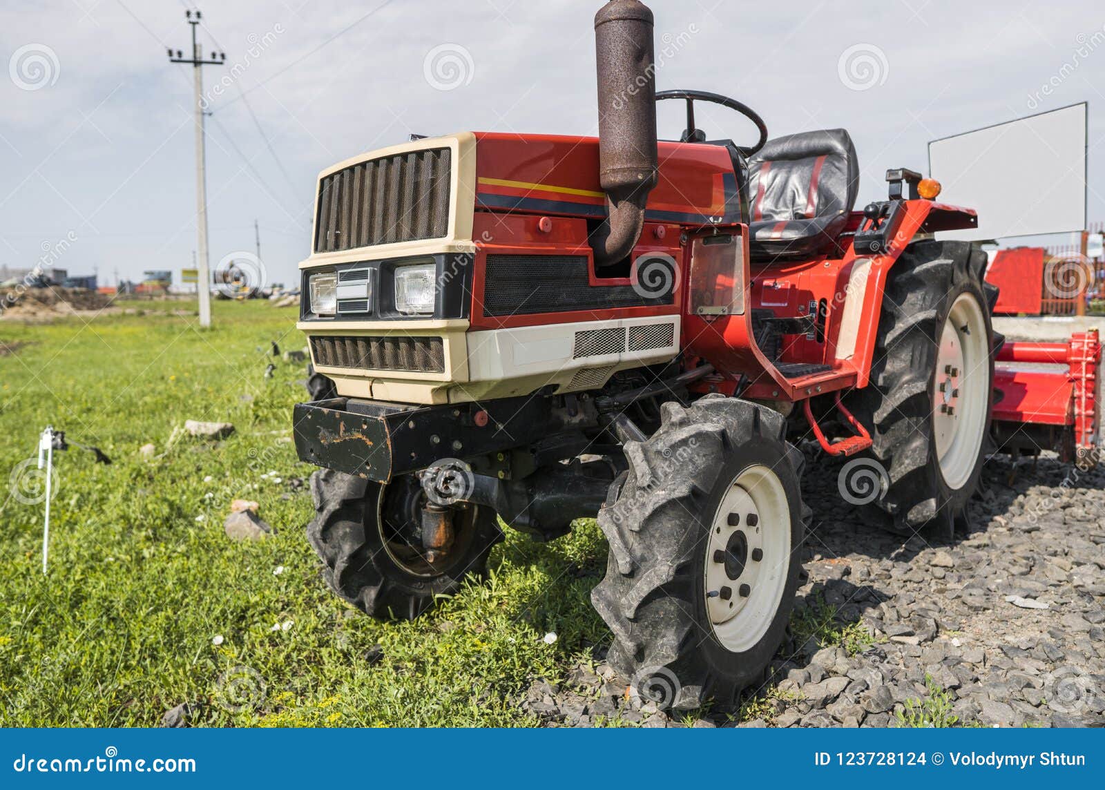 A Small Mini Red Tractor Stands on a Farm Yard on Green Grass and Waits ...