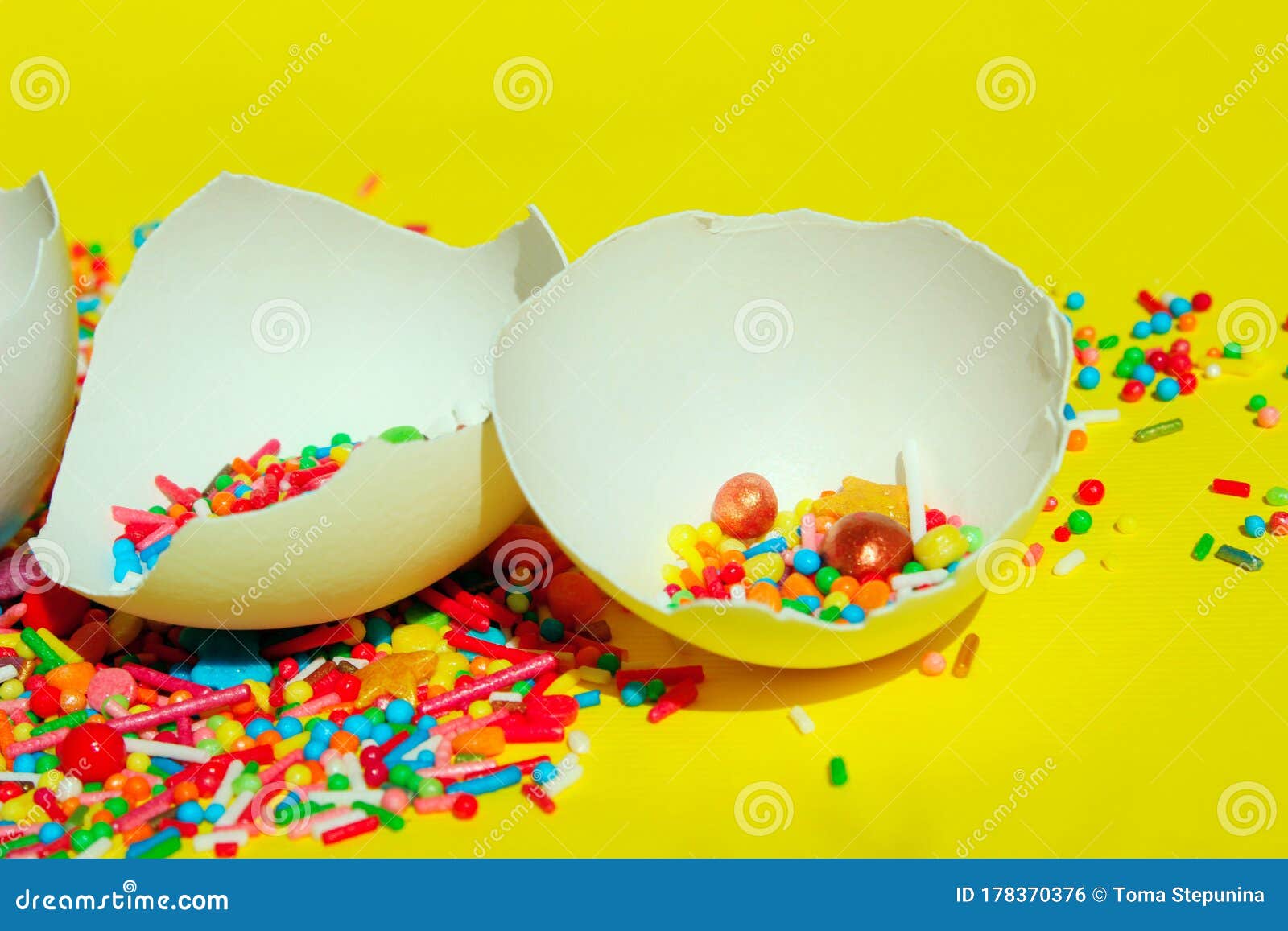 Small Multi-colored Sweets in a Broken White Egg Shell on Yellow ...