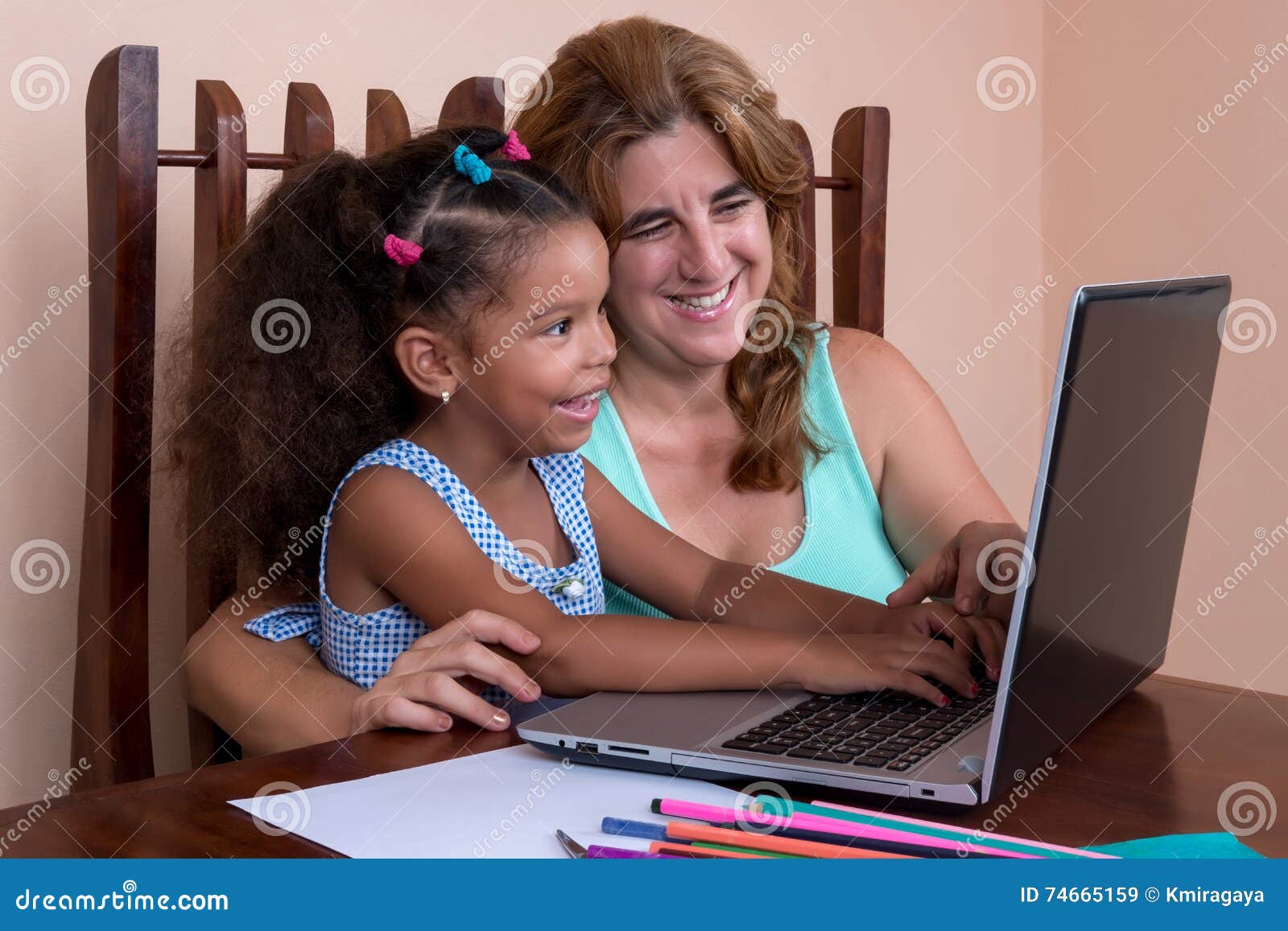 Small Multiracial Girl And Her Mother Working On A Laptop Comput Stock