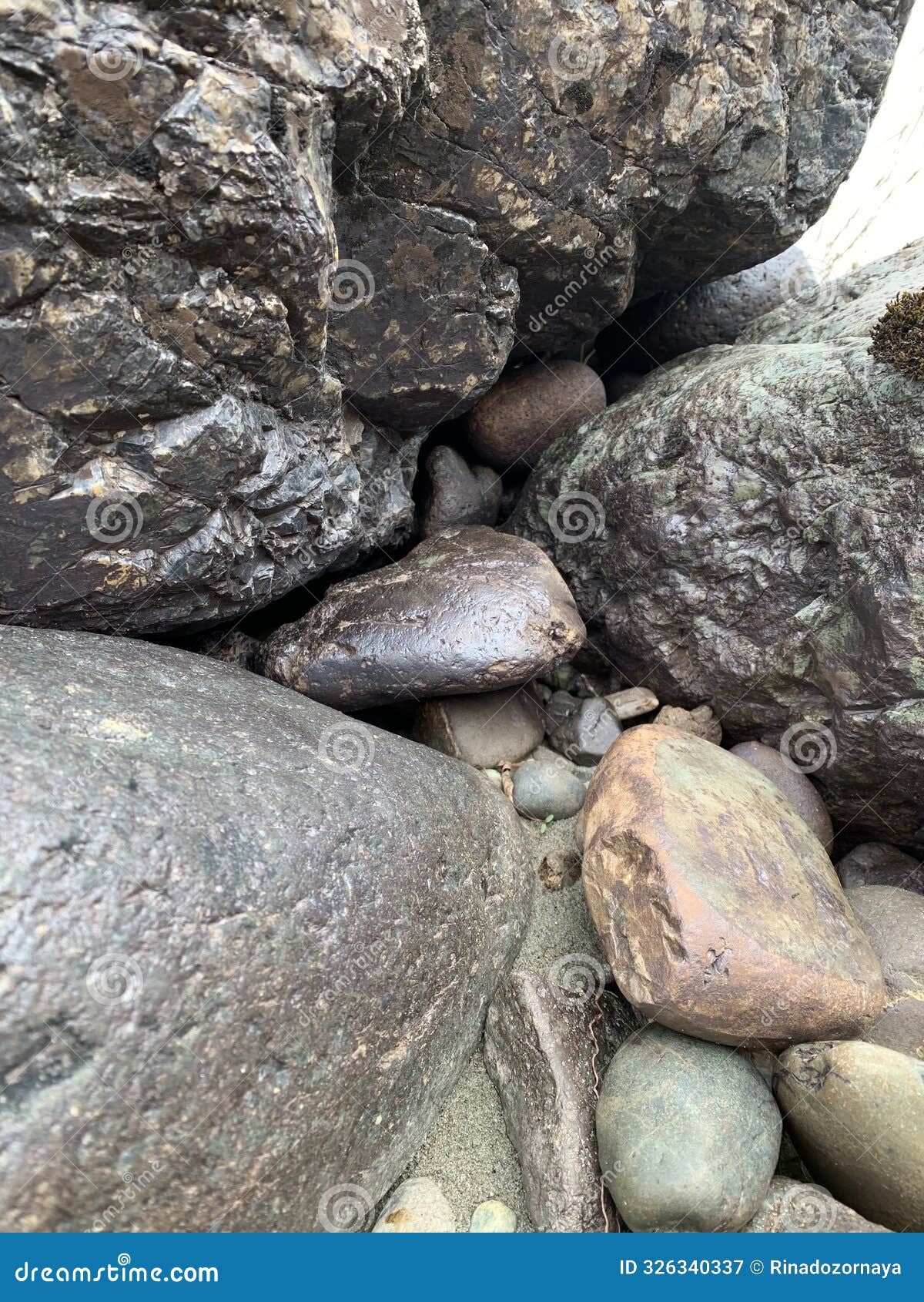 Small Pebbles and a Large Rock on the Beach with a Smooth Surface and ...