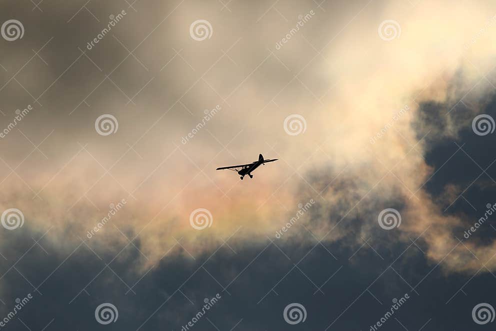 Small Plane Flying in the Sky Against Dark Clouds Stock Image - Image ...