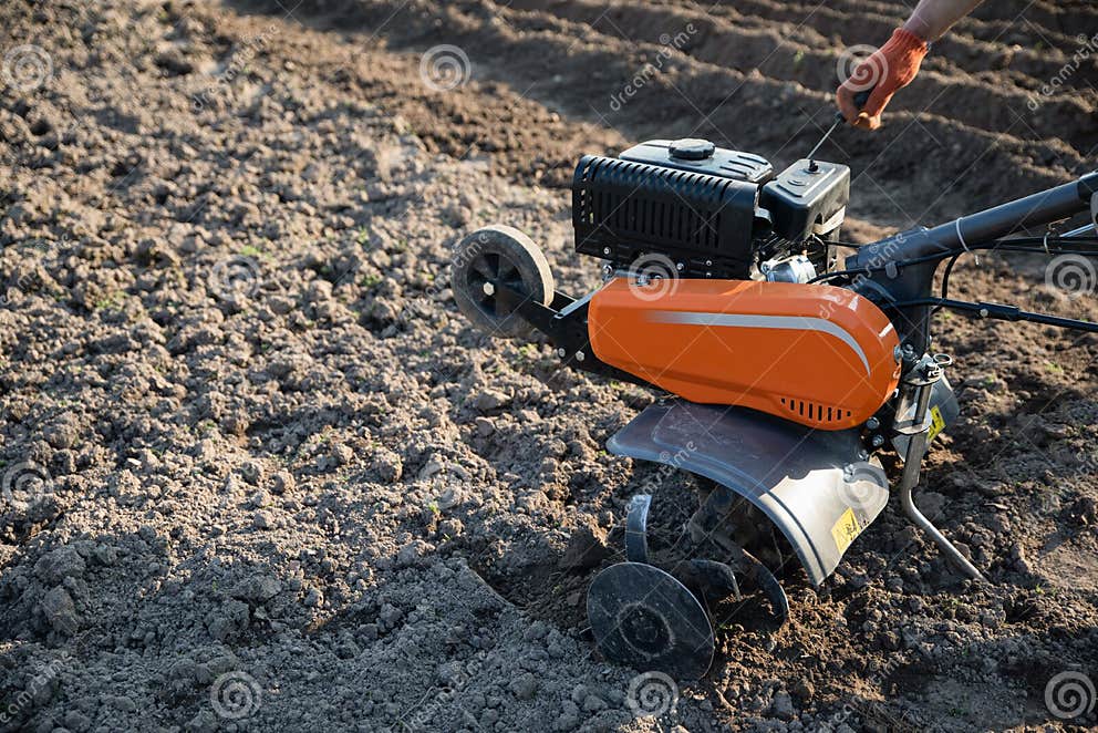 Small Plowing Machine in Hands of a Farmer Making Arable in Black Soil ...