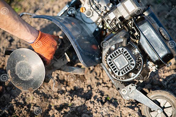 Small Plowing Machine in Hands of a Farmer Making Arable in Black Soil ...