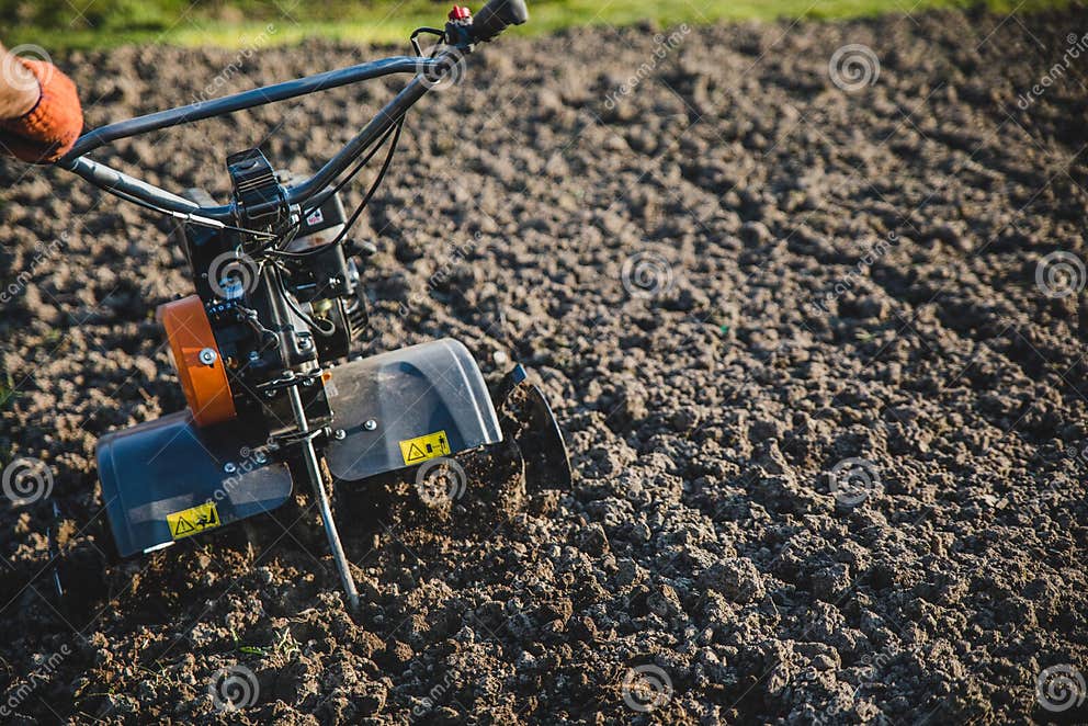 Small Plowing Machine in Hands of a Farmer Making Arable in Black Soil ...