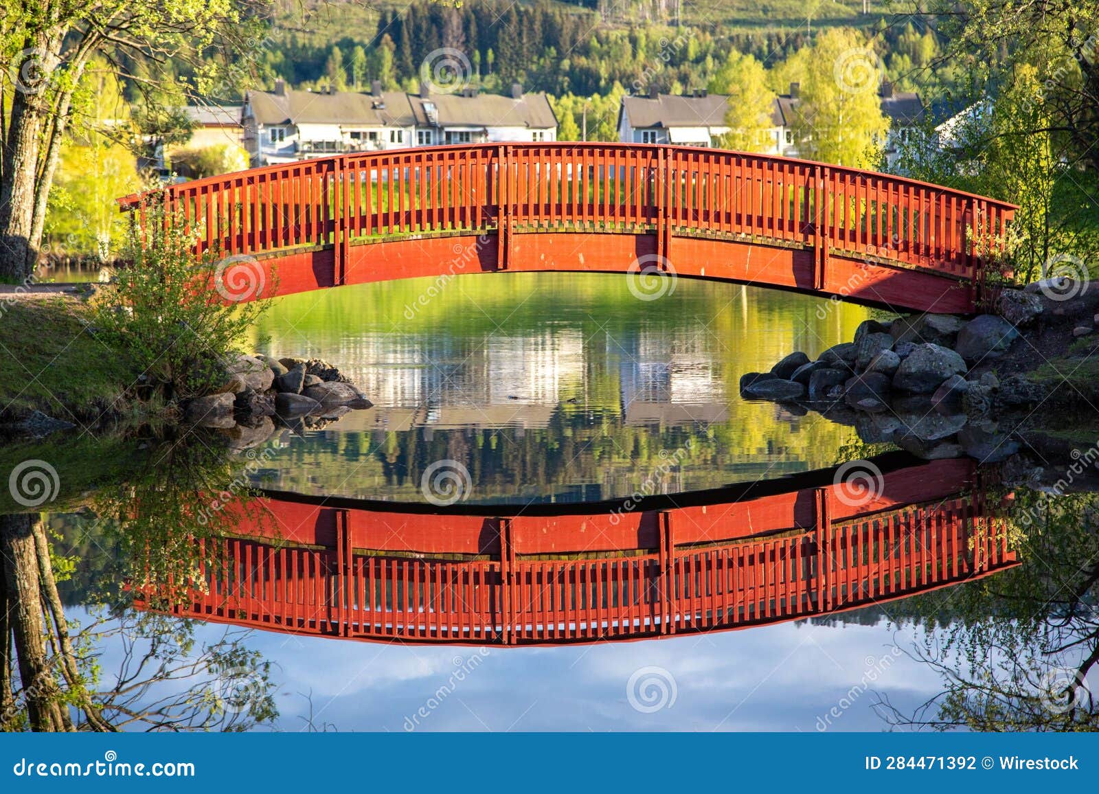 Small Red Bridge Over a Tranquil Lake in a Lush Green Park with ...