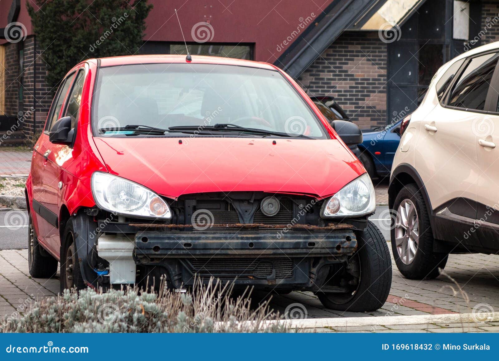 A Small Red Hatchback Car with Missing Frontal Par after a Traffic ...