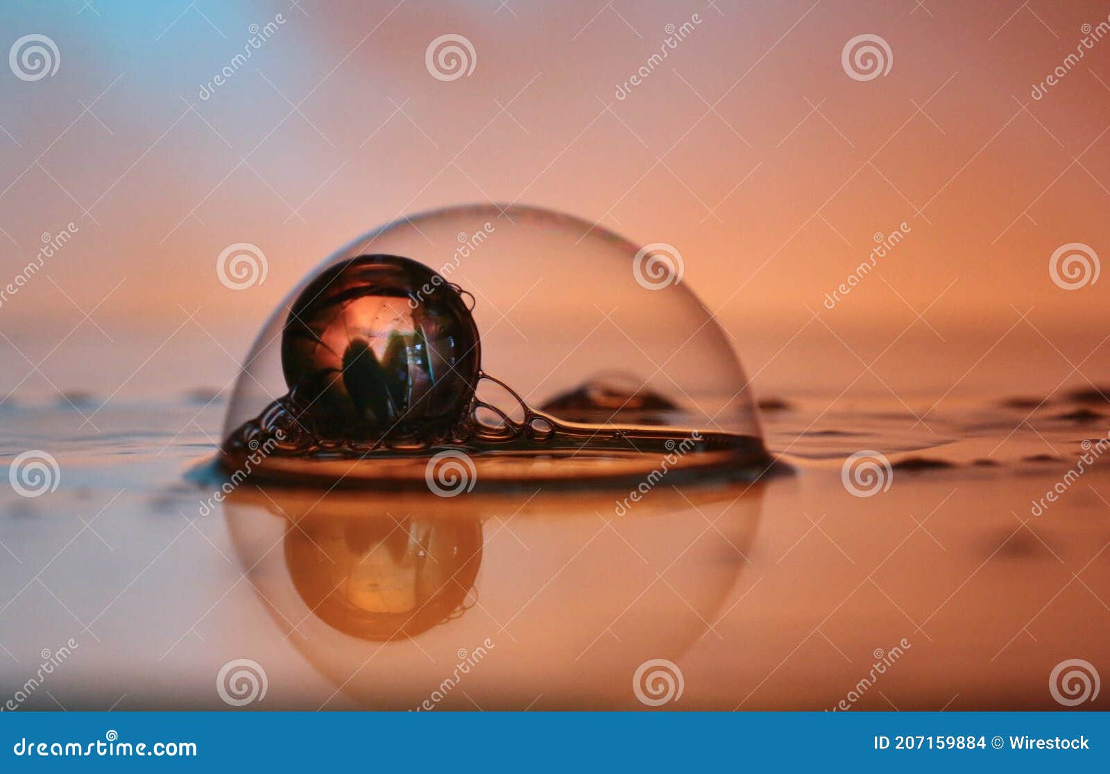 Small Reflective Crystal Ball Inside of a Bubble on a Smooth Wet ...