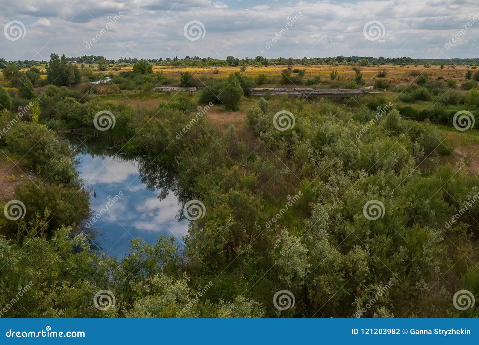 A Small River Running through Fields and Reflection of Clouds in the ...