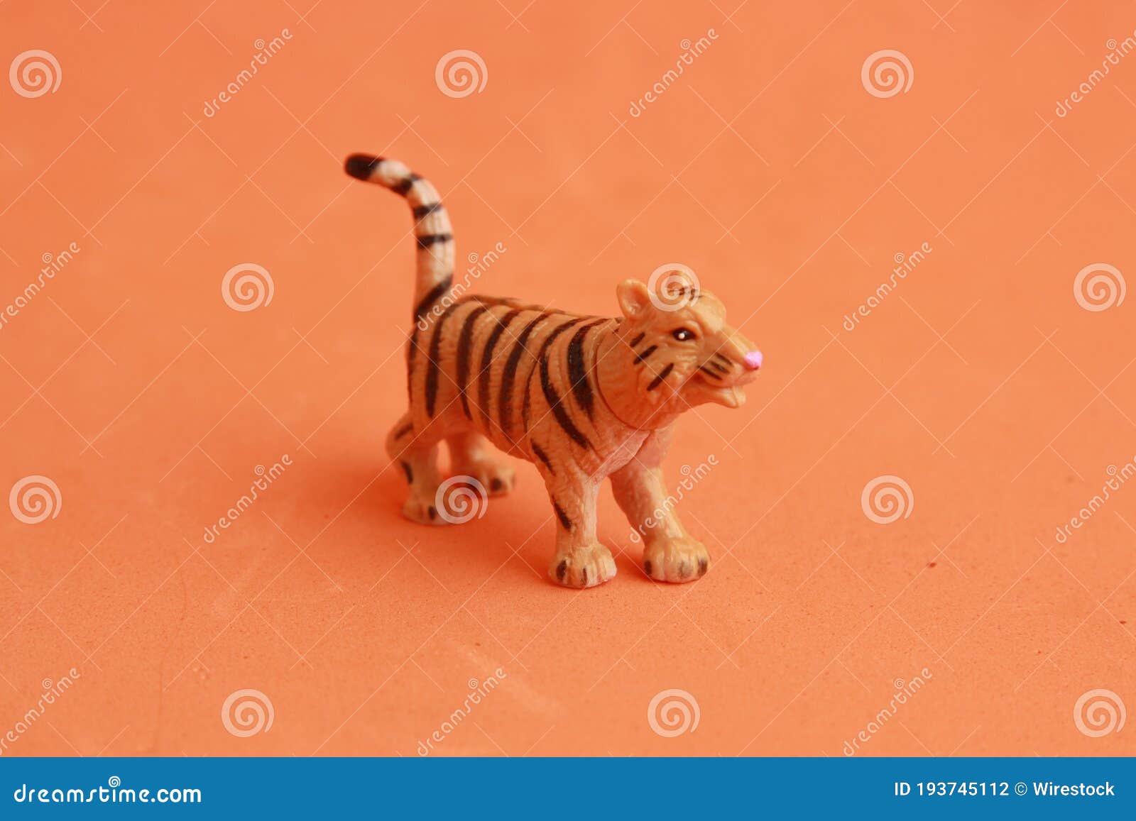Small Rubber Tiger Toy Isolated on an Orange Background Stock Photo ...