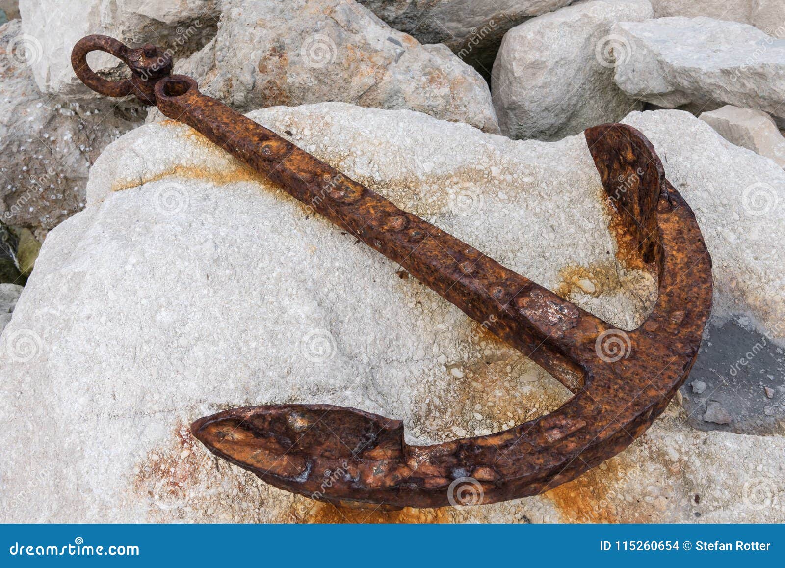 Small Rusty Anchor Lying on Rocks in a Harbor Stock Photo - Image of ...