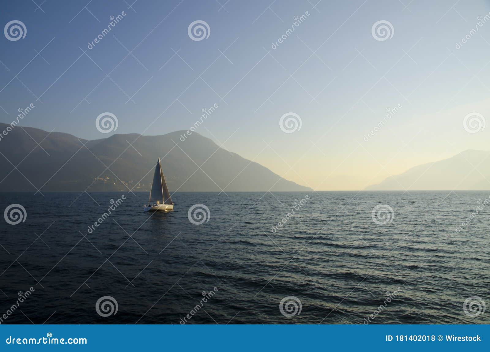 Small Sailing Boat in the Lake with the Sunset in the Background Stock ...