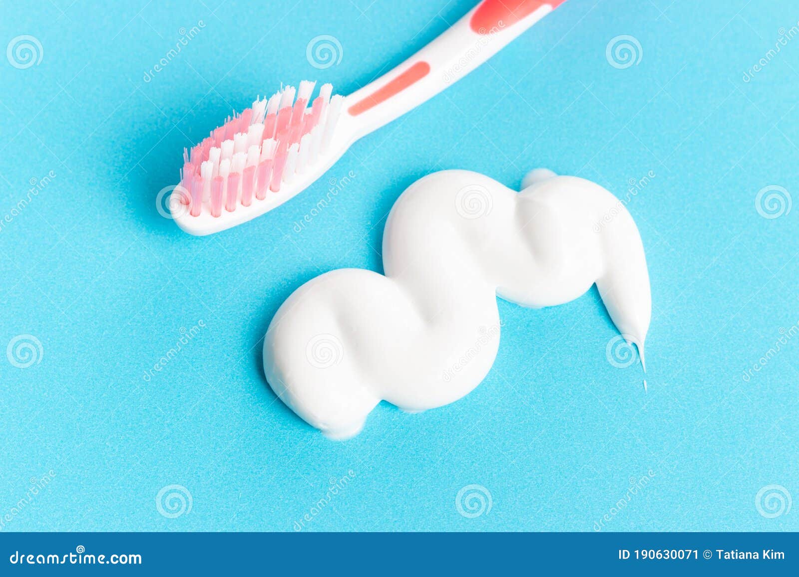 A Small Smear of Toothpaste and Toothbrush on a Blue Background Stock ...