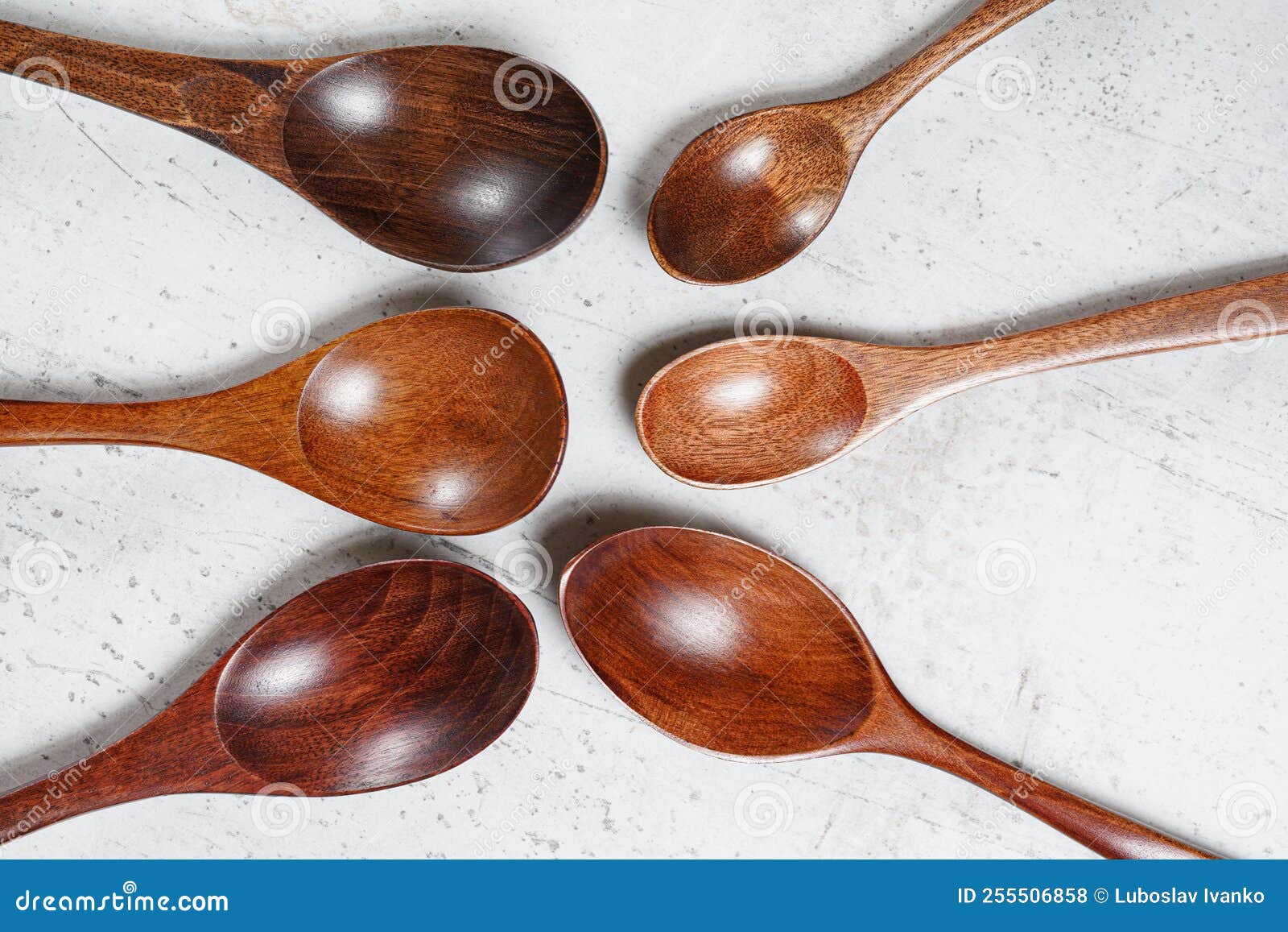 Small Spoons Made of Dark Wood, on White Working Board, View from Above ...